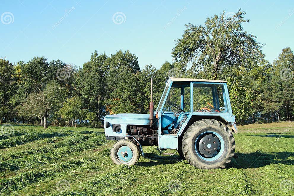 Tractor on the meadow stock photo. Image of wheals, blue - 21608472