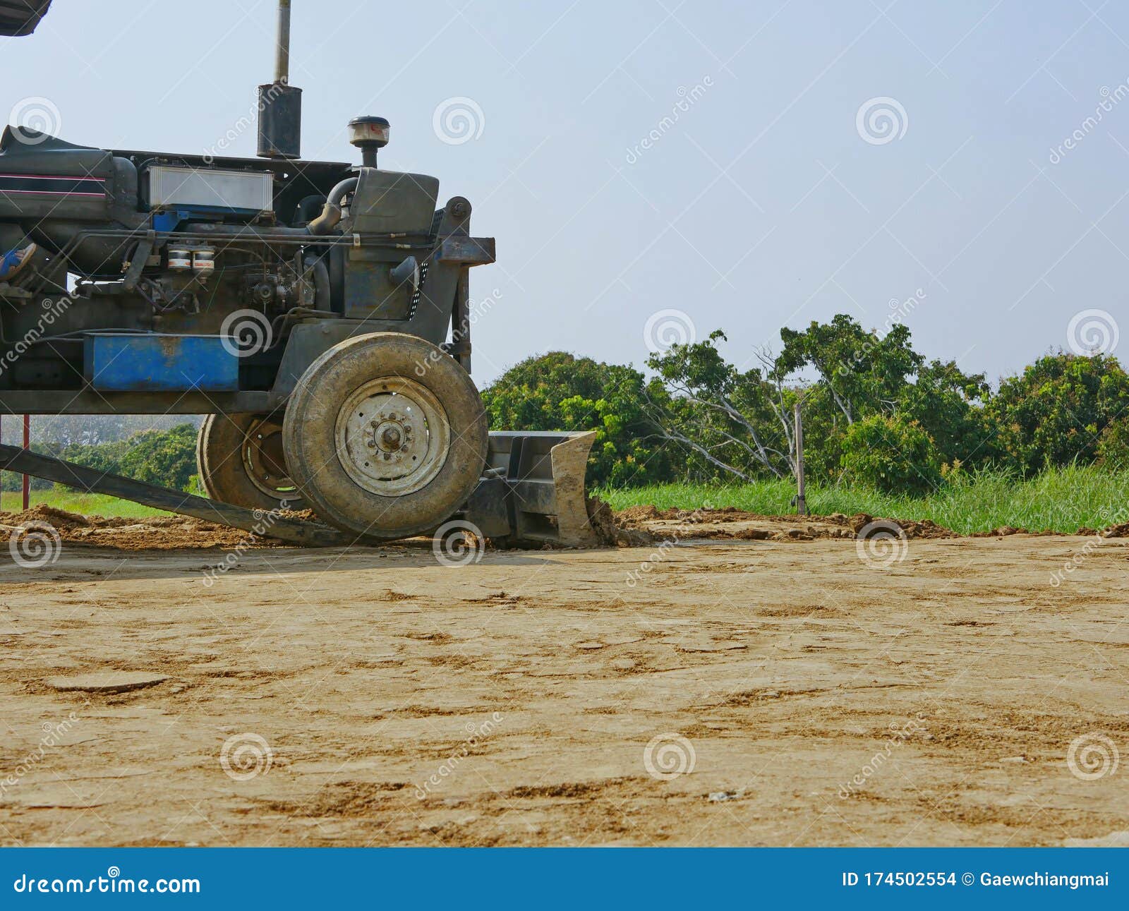 A Tractor Mounted with Front Grader is Preparing an Entrance Ramp ...