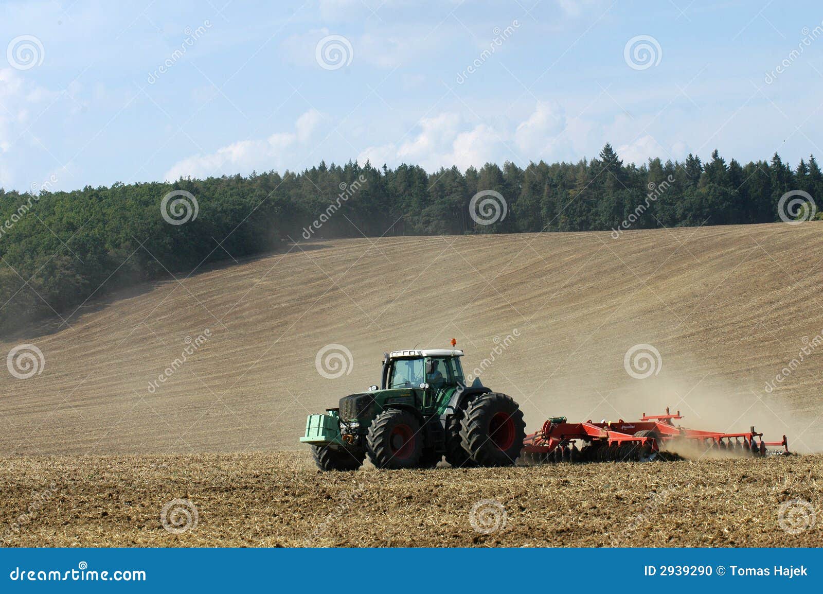 Tractor Ploughing Field With Blurry Farm In The Background Royalty-Free ...