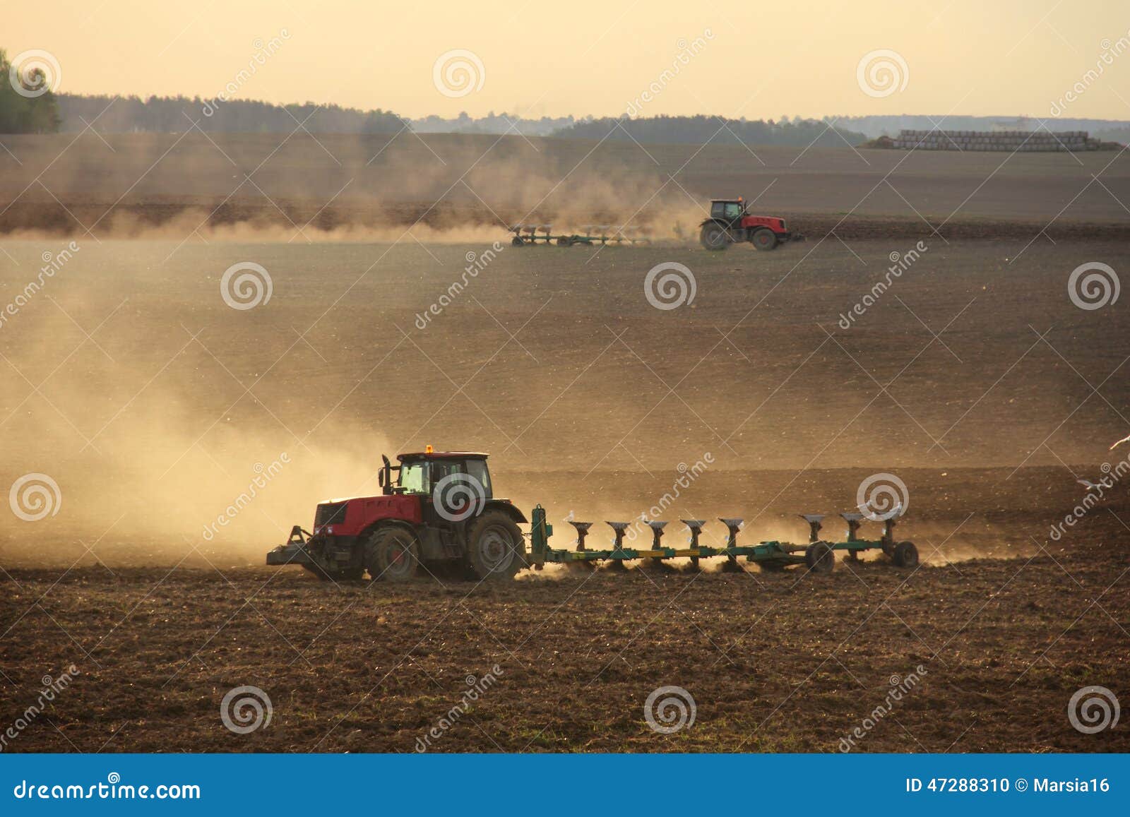 Tractor Plowing Field With Silos In Background Stock Photography ...