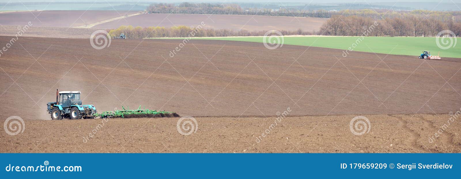 A Tractor Plowing and Sowing in the Field. Panoramic Format Stock Image ...