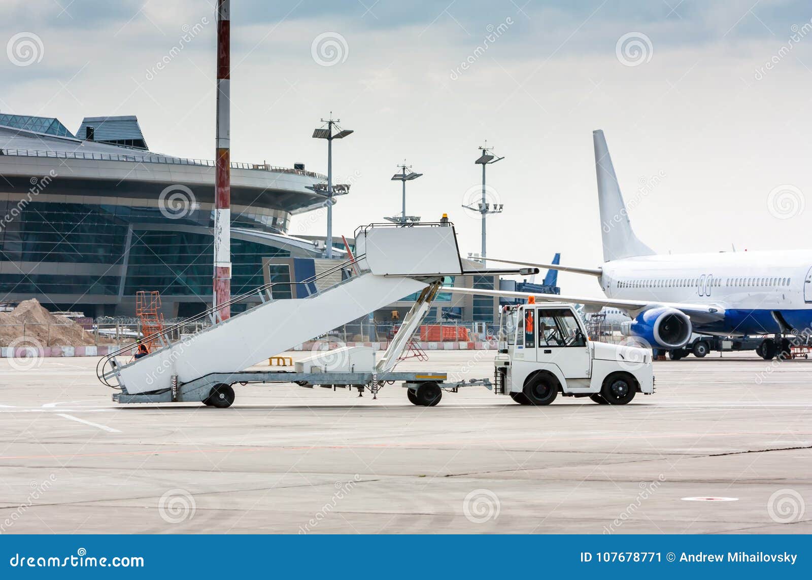 The Tractor Pulls the Passenger Boarding Stairs at the Airport Apron ...