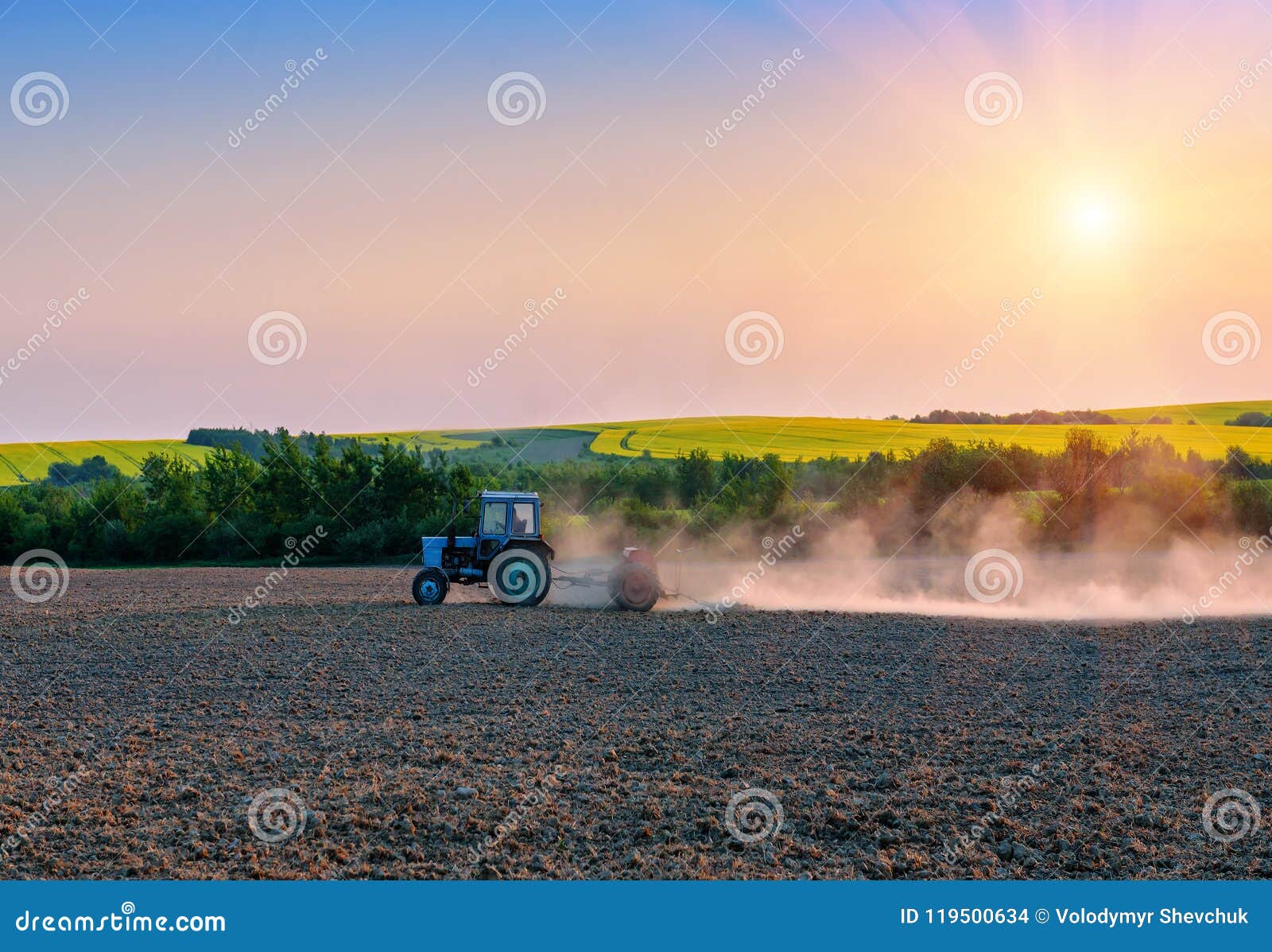The Tractor Pulls the Plow in the Field on Sunset Stock Photo - Image ...