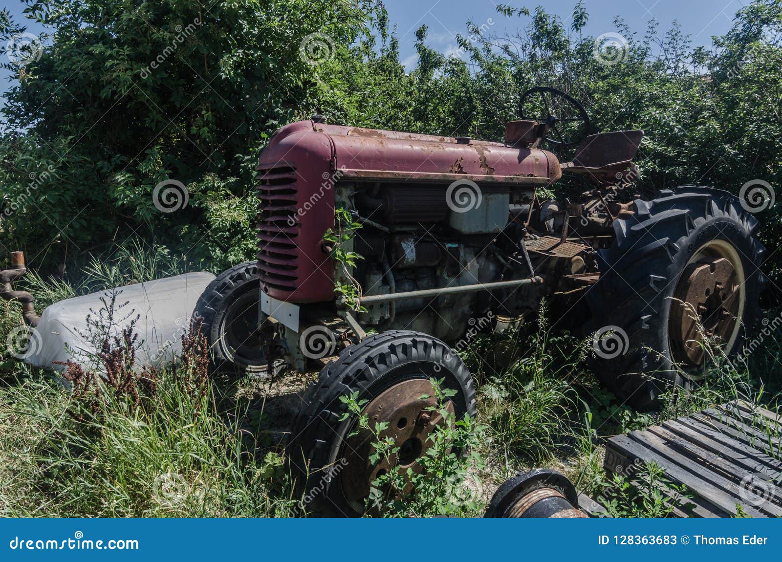 Tractor rojo en un terreno imagen de archivo. Imagen de olvido - 128363683