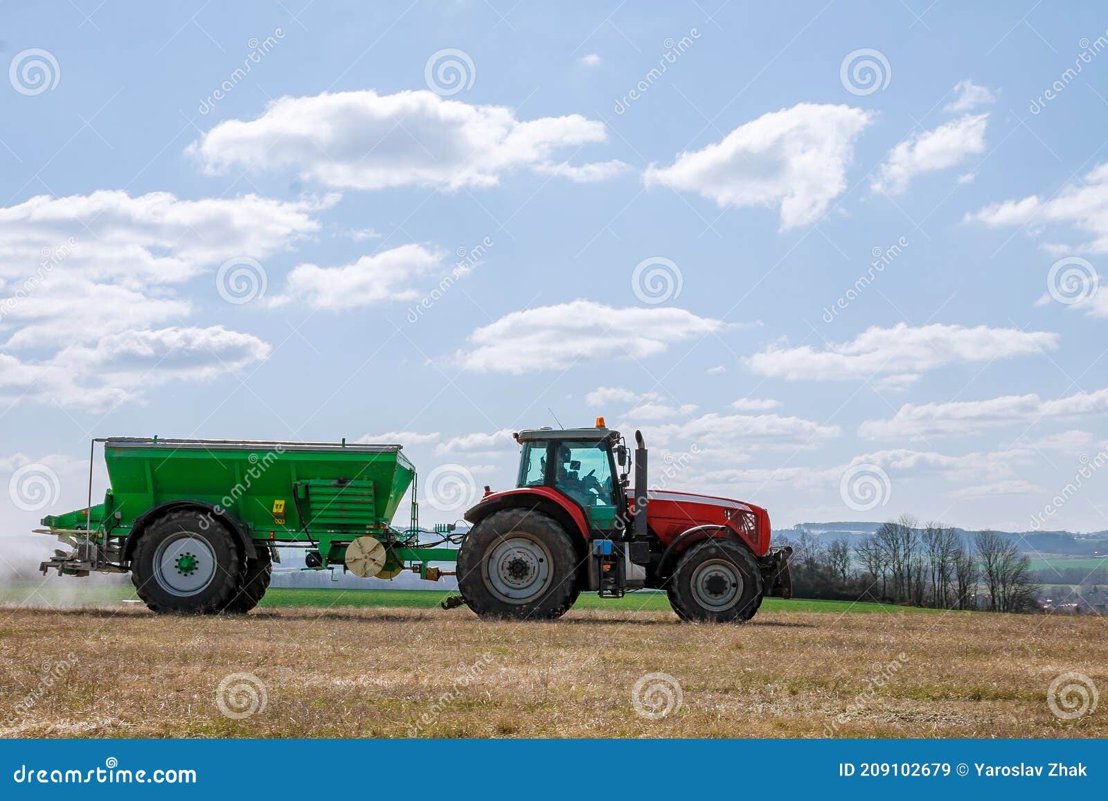 Tractor Spreading Fertilizer on Grass Field. Agricultural Work Stock ...