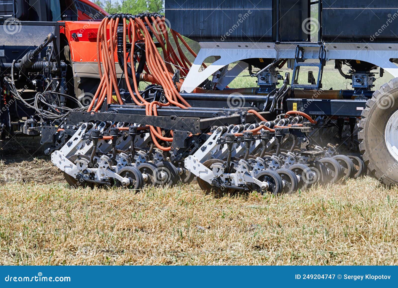 The Tractor Works in the Field with an Automatic Seeder Stock Image ...