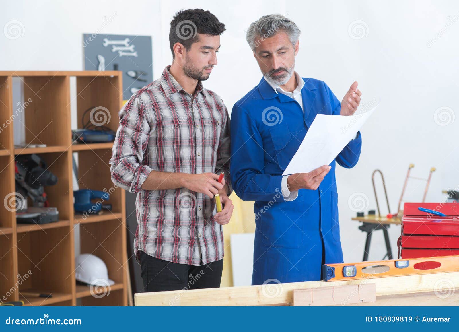 Tradesmen Looking at Paperwork in Workshop Stock Image - Image of ...