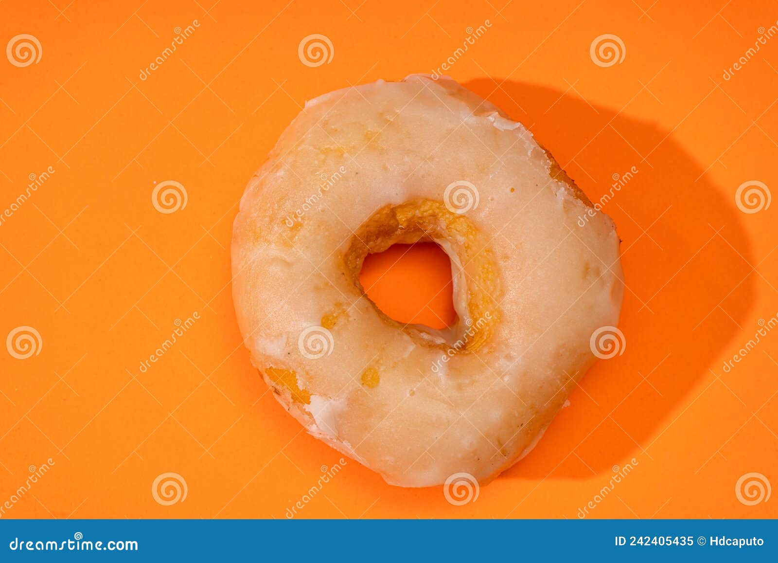 Traditional Donut Covered with Icing on an Orange Surface.Traditional ...