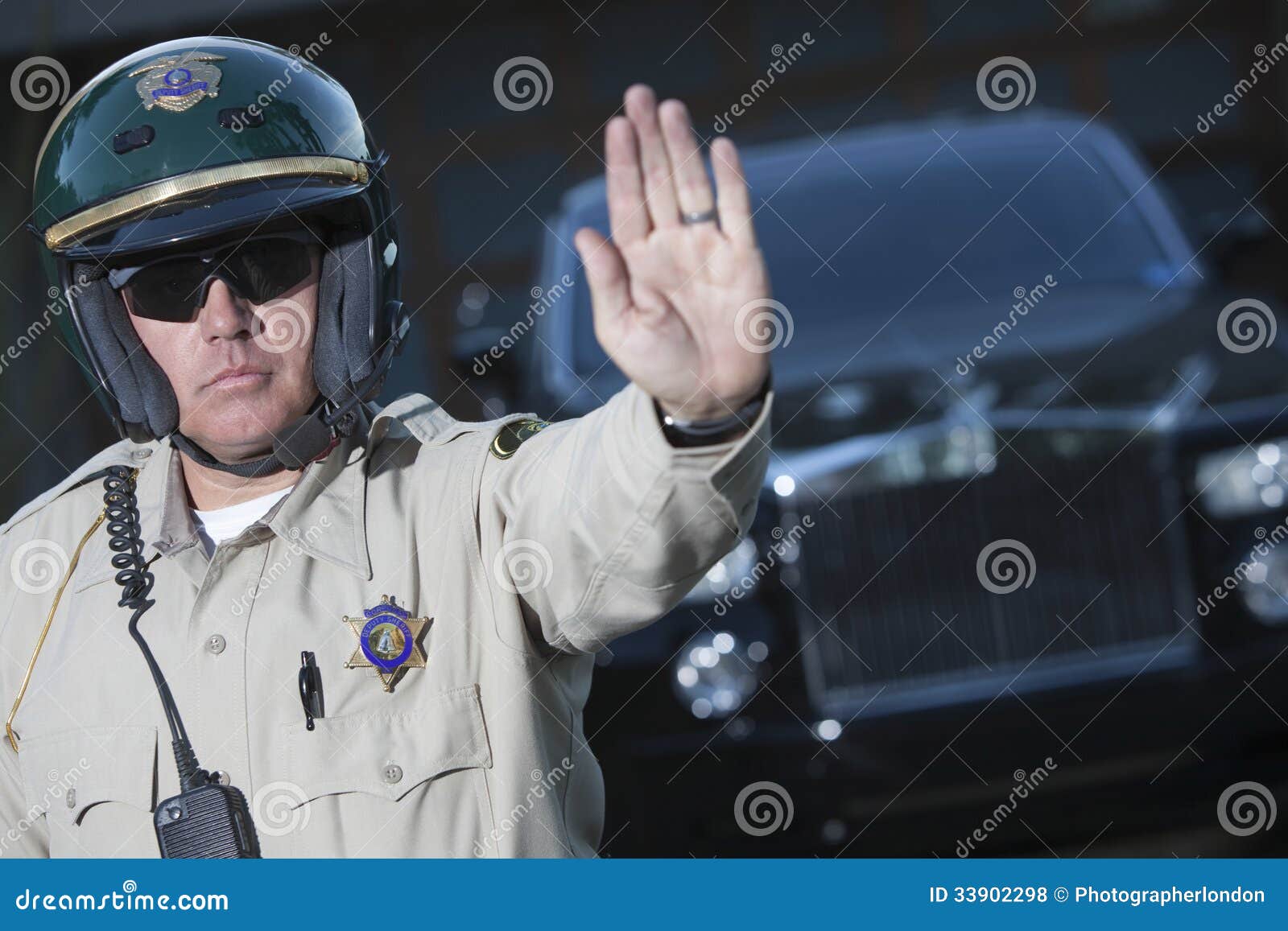 Traffic Cop Signaling Stop Gesture with Car in Background Stock Photo ...