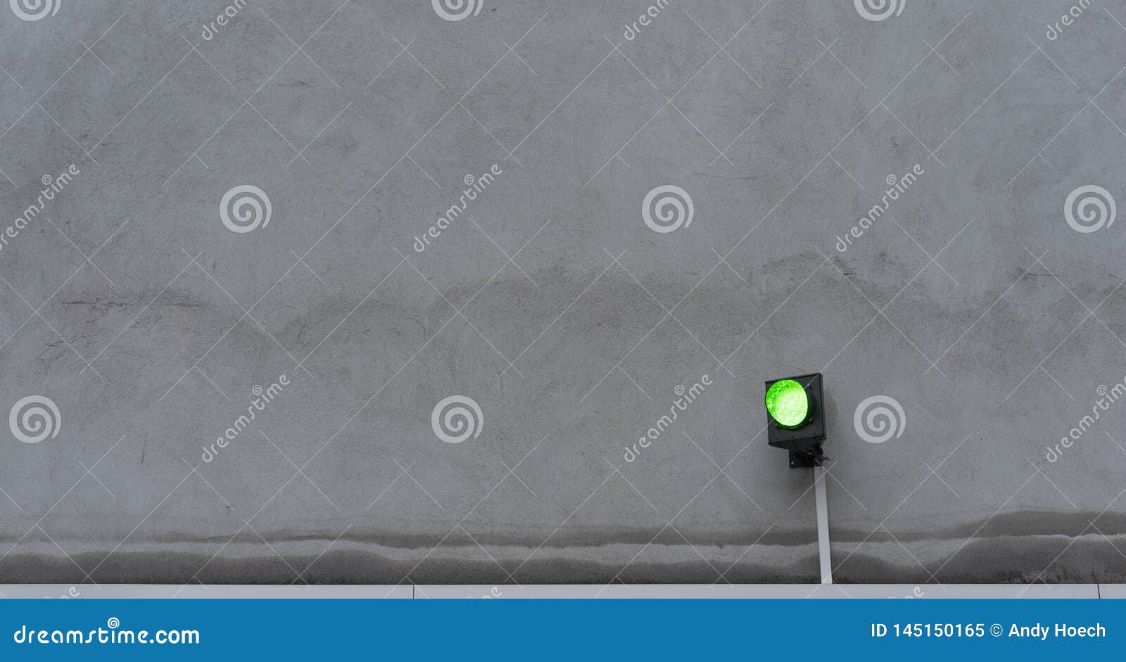 The Traffic Light Glows Green in Front of the Gray Wall Stock Image ...
