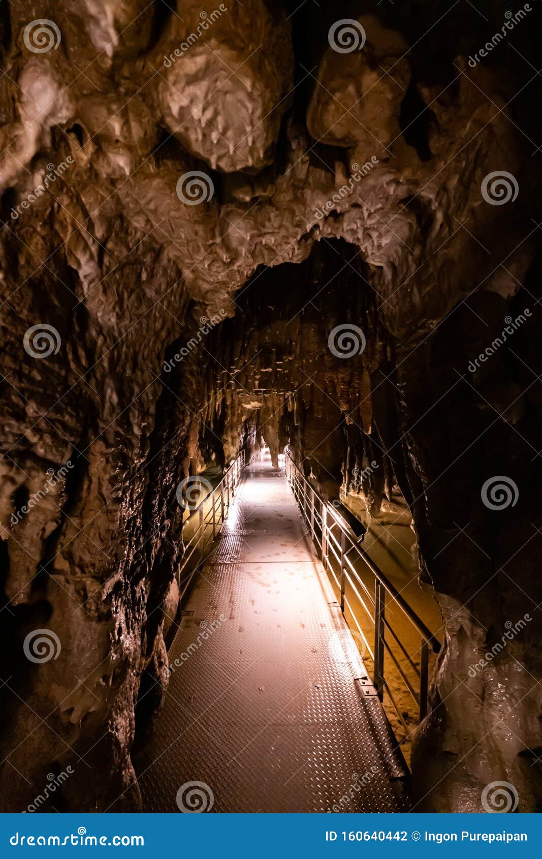 Trail Inside a Dark and Damp Cave. There are Lighting Attached Along ...