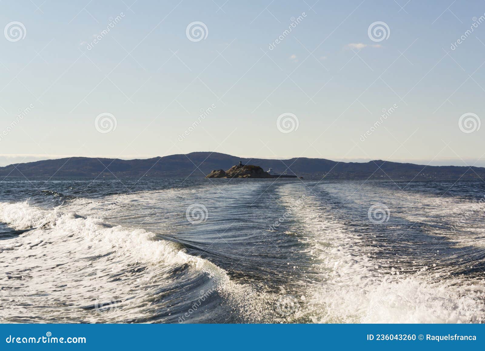 Trail on Water Surface of Fast Moving Boat with Mountains on the ...
