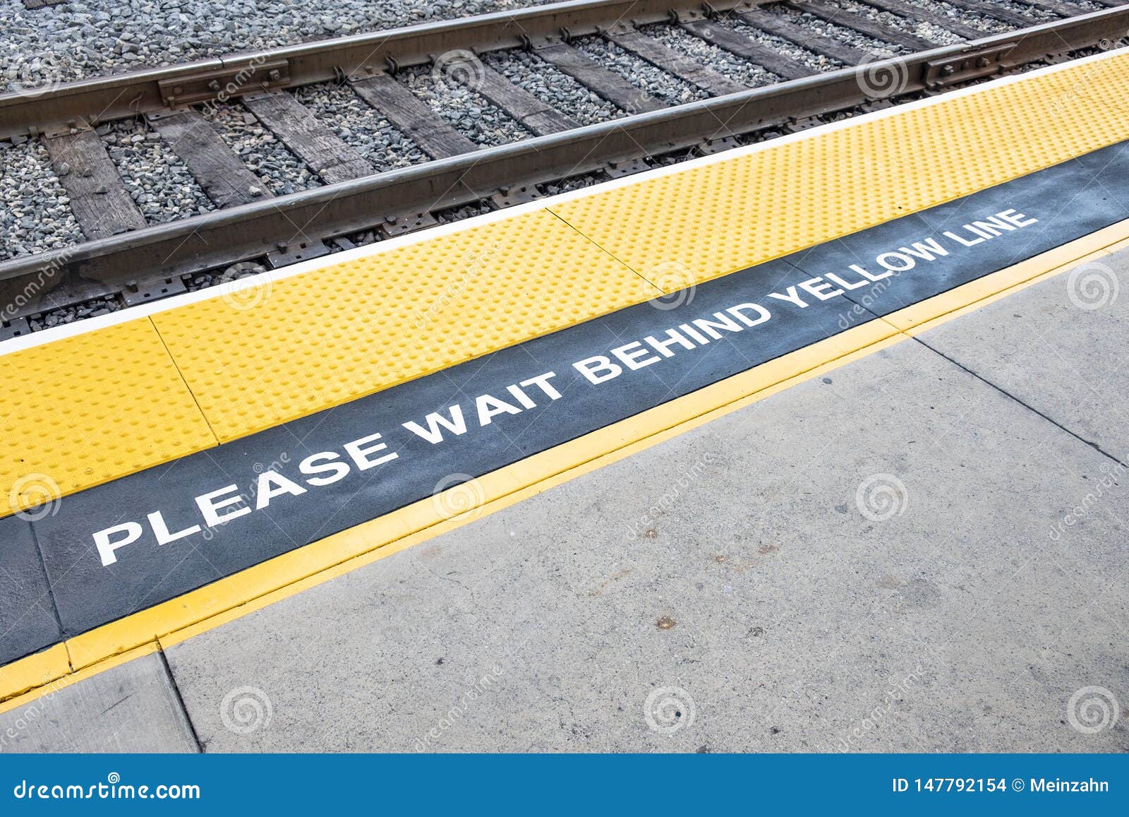 Train Platform with Sign Please Wait Behind the Yellow Line and Yellow ...