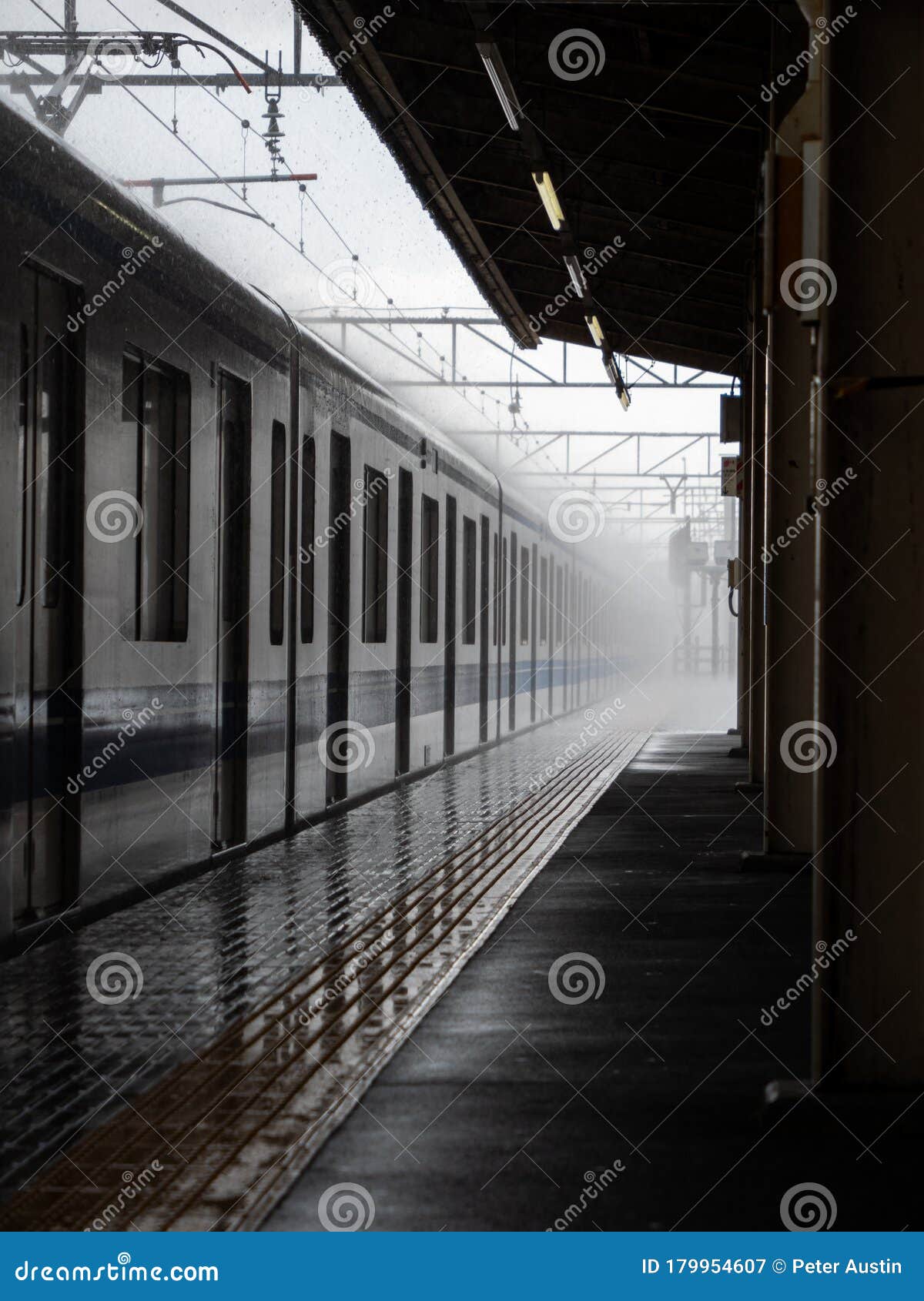 A Train Pulling into a Station in Heavy Rain Stock Image - Image of ...