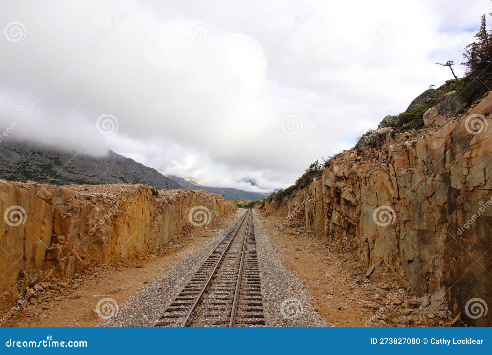 Train Tracks Running through a Mountain Range with a Stream Flowing ...