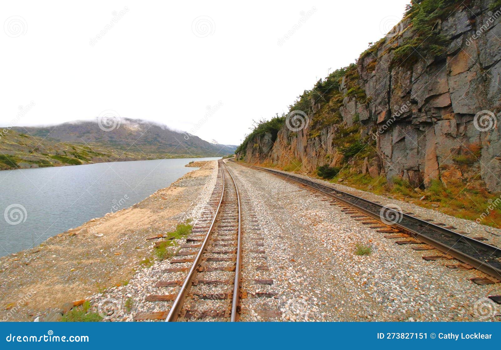 Train Tracks Running through a Mountain Range with a Stream Flowing ...