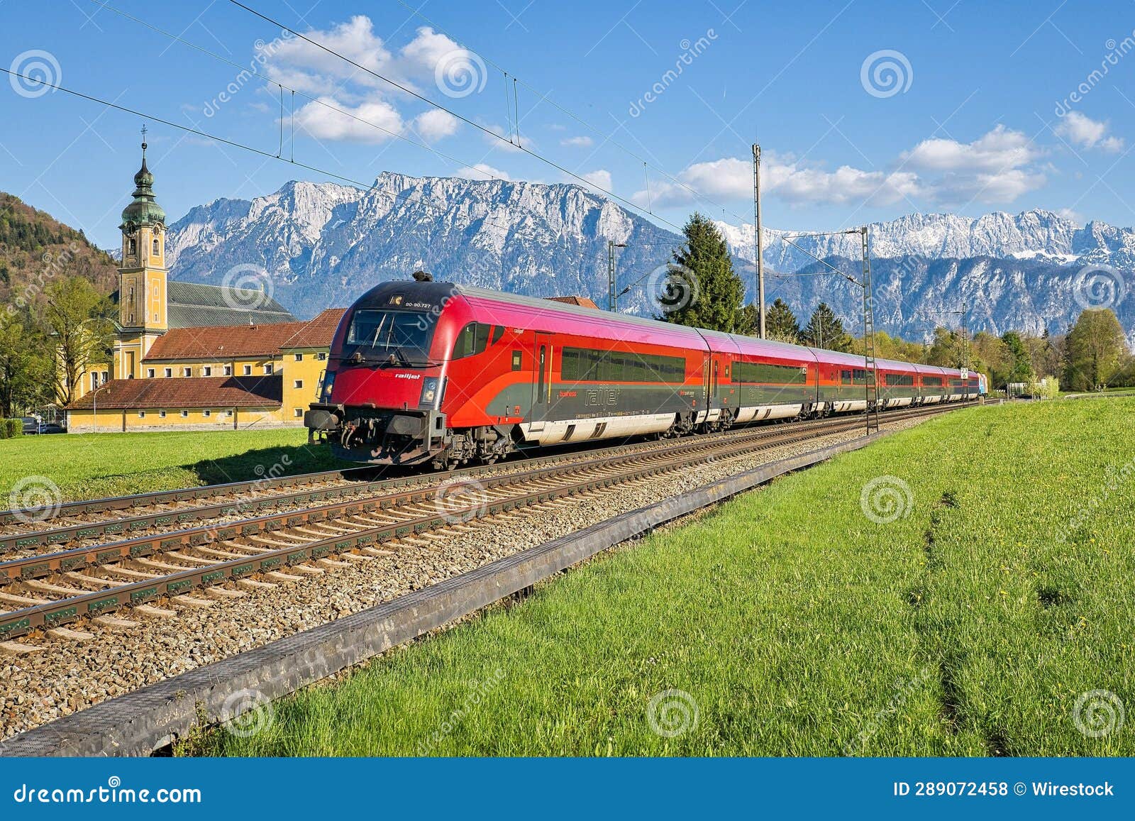Train is Travelling Along a Railway Track, Surrounded by Lush Green ...