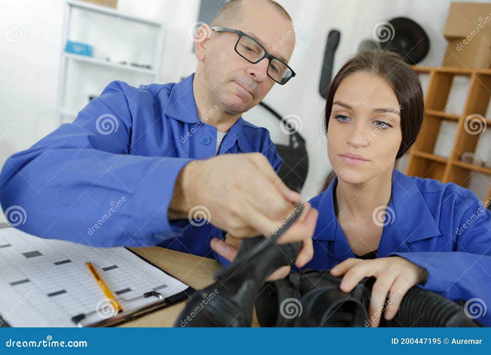 Trainee Apprentice Mechanic with Instructor Identifying Parts Stock ...