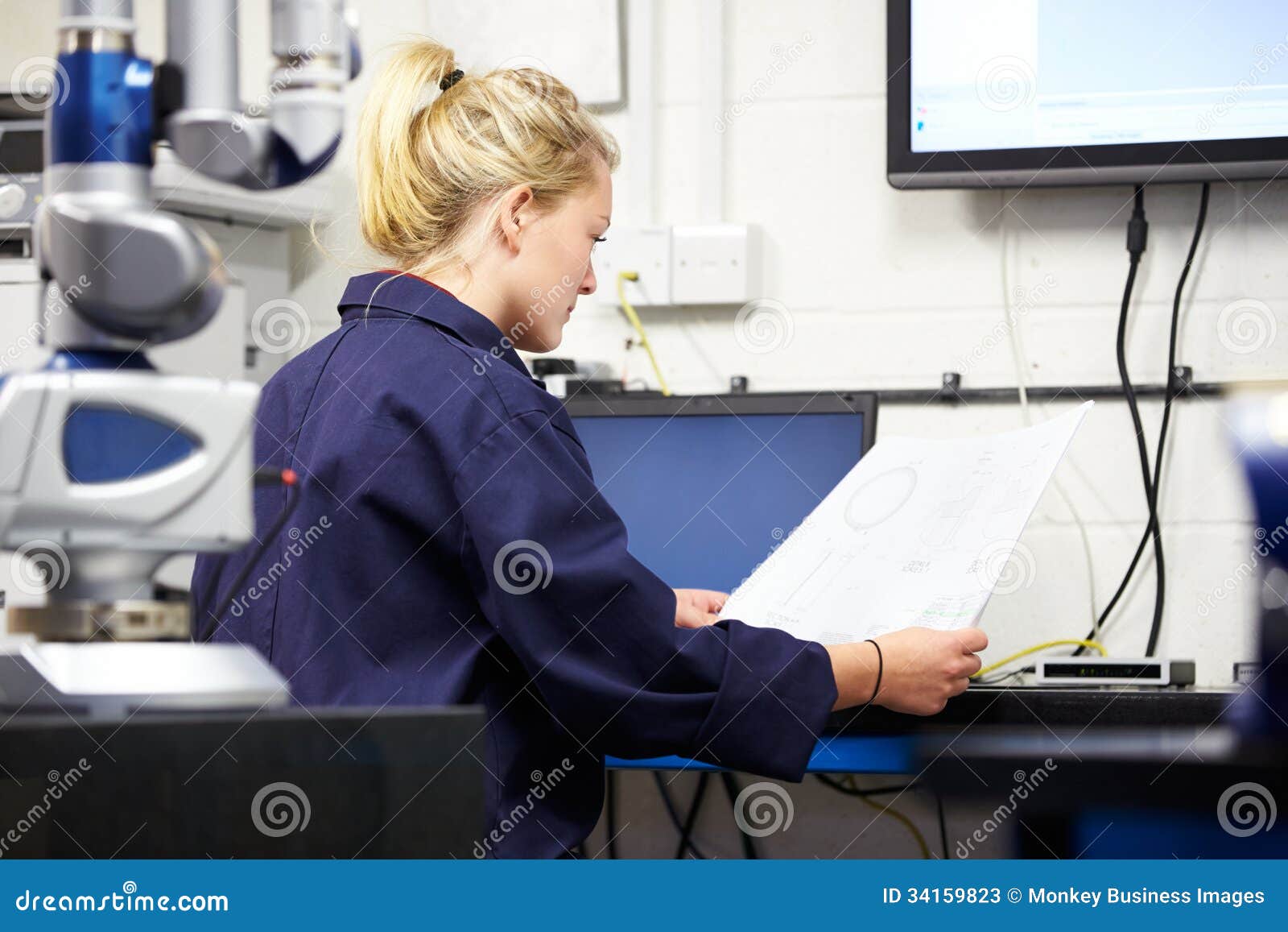 Trainee Engineer Studying Plans with CMM Arm in Foreground Stock Image ...