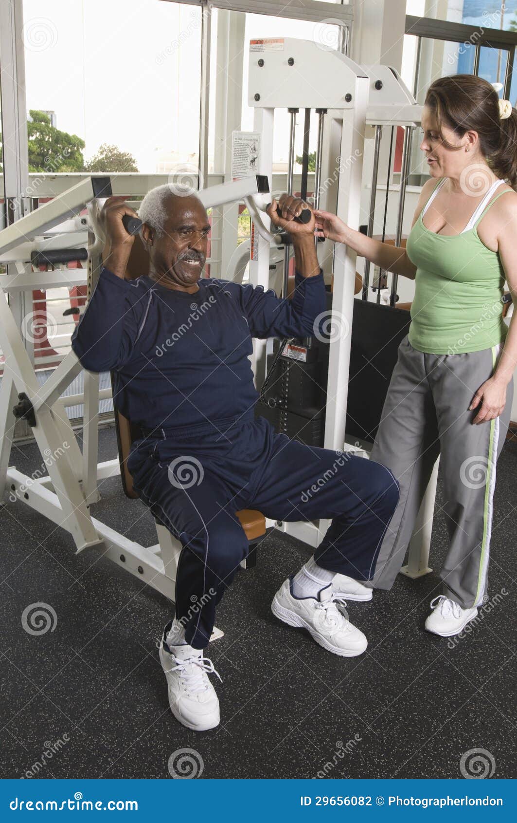 Trainer Assisting Senior Man Lifting Weights Stock Photo - Image of ...