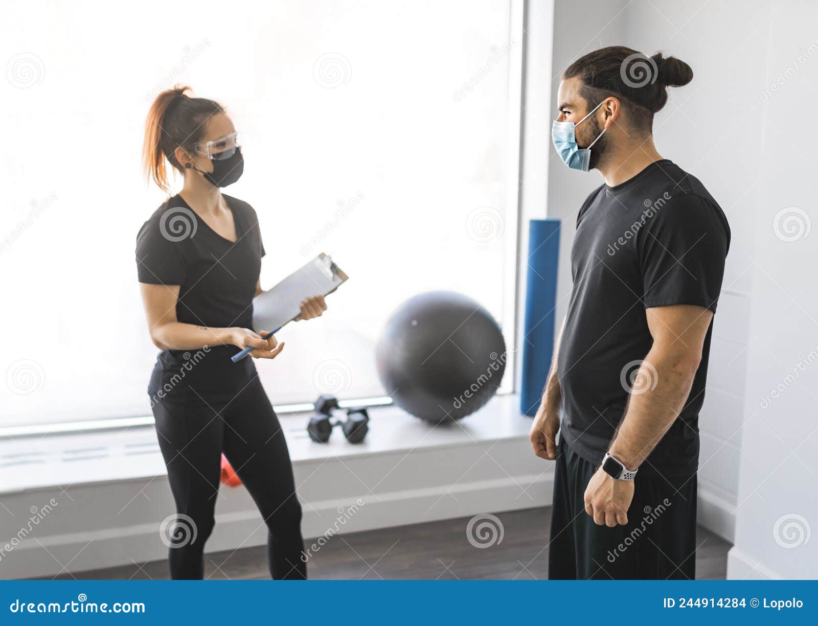 Trainer and Client Discussing Her Progress at the Gym with Mask Stock ...