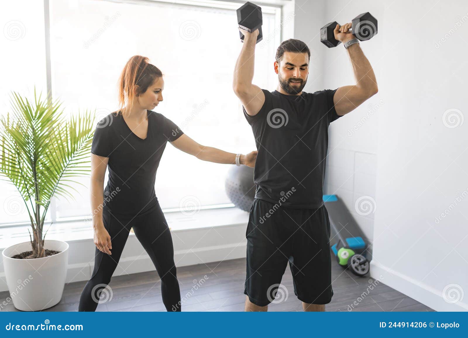 Trainer and Client Training with Dumbbell at the Gym Stock Photo ...