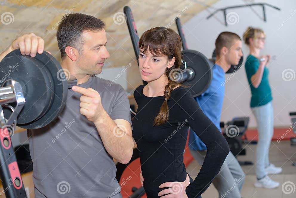 Trainer Explaining How To Use Training Machine in Gym Stock Photo ...