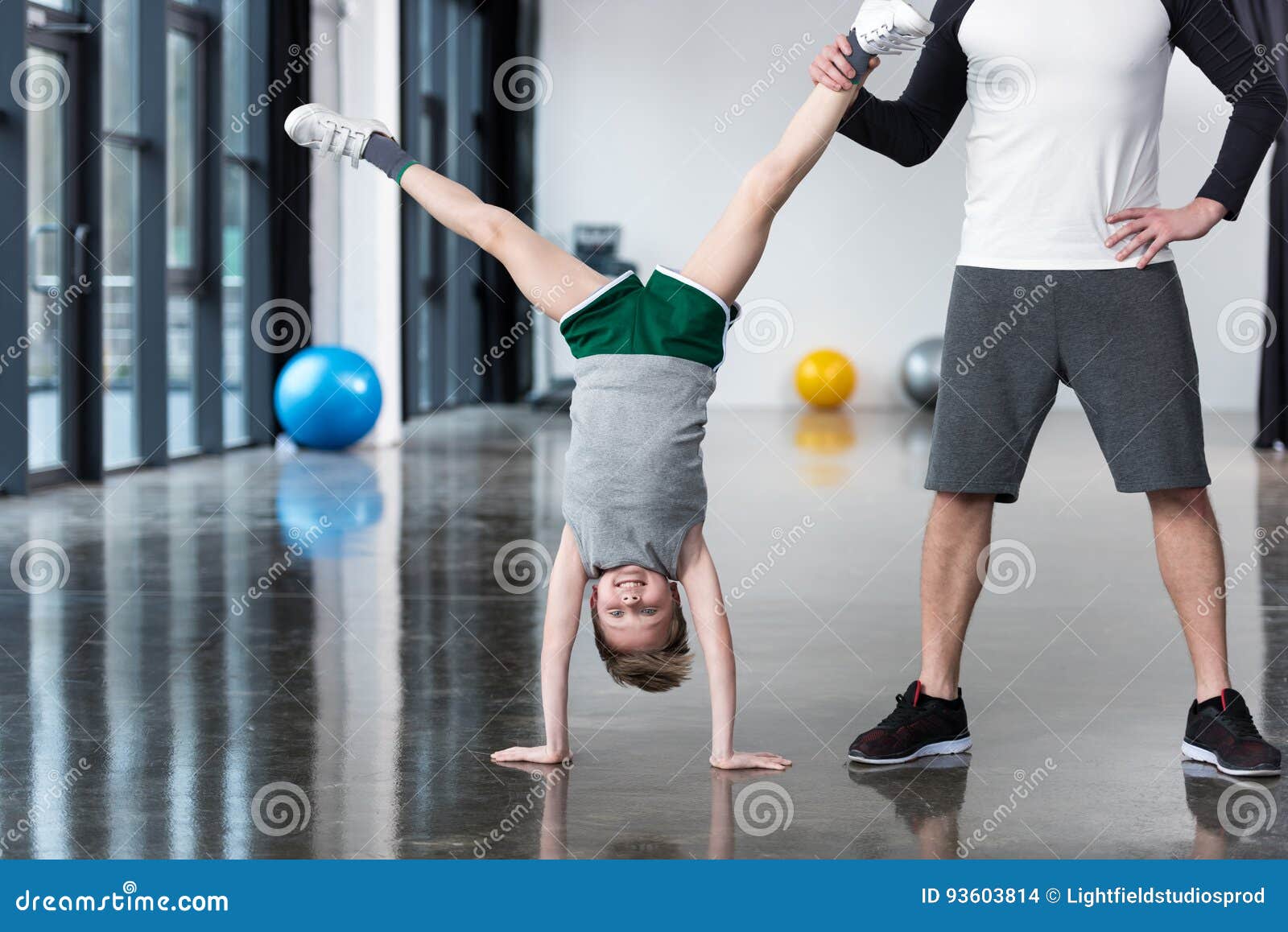 Trainer Helping Boy Standing on Hands Stock Photo - Image of standing ...