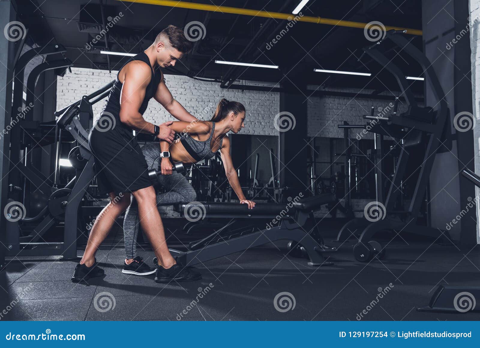 Side View of Young Trainer Helping Woman Stock Photo - Image of trainer ...