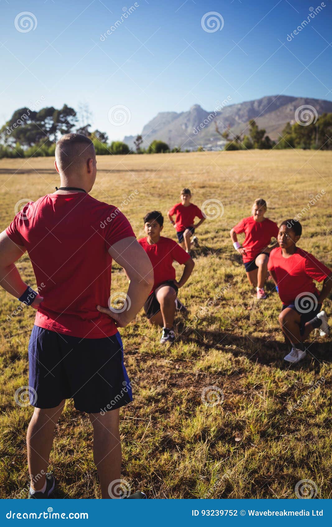 Trainer Instructing Kids while Exercising in the Boot Camp Stock Photo ...