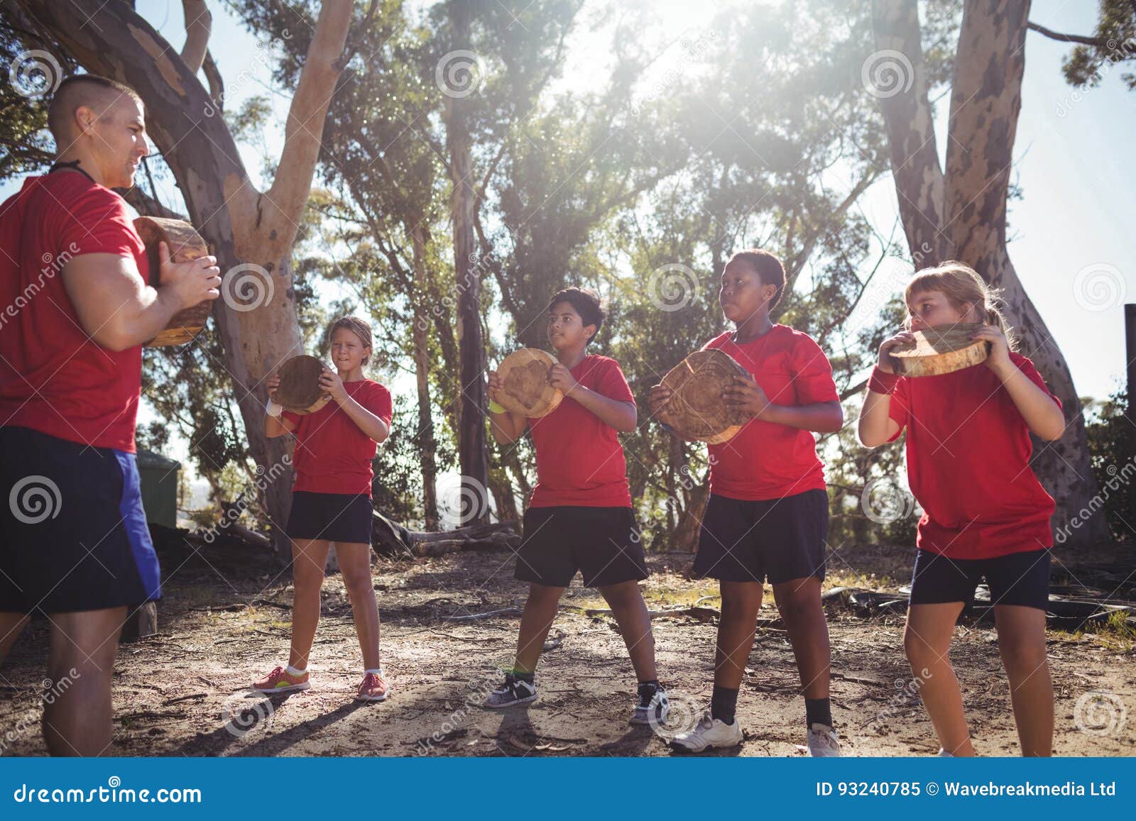 Trainer and Kids Carrying Wooden Logs during Obstacle Course Training ...