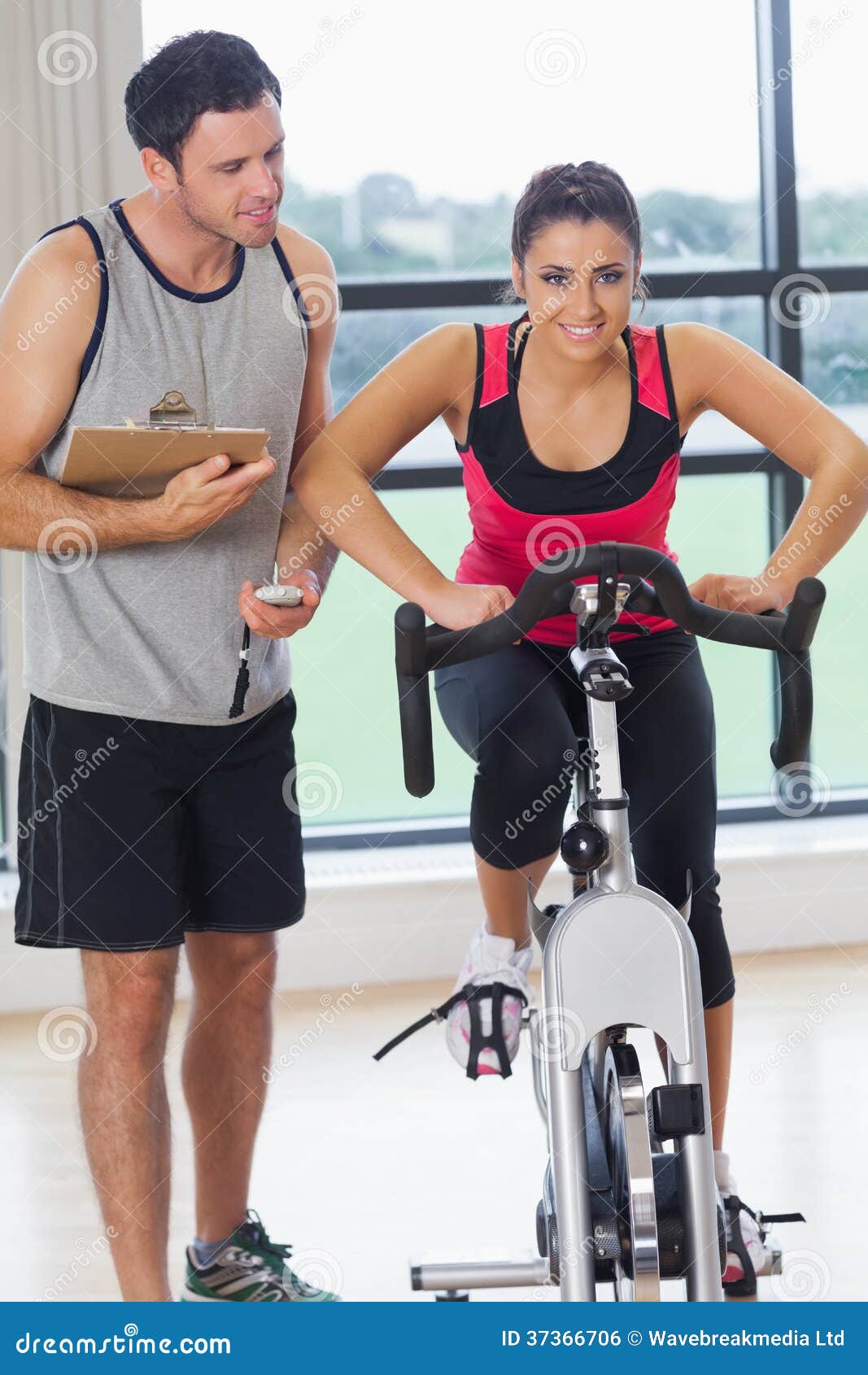 Trainer Watching Woman Work Out at Spinning Class Stock Photo - Image ...