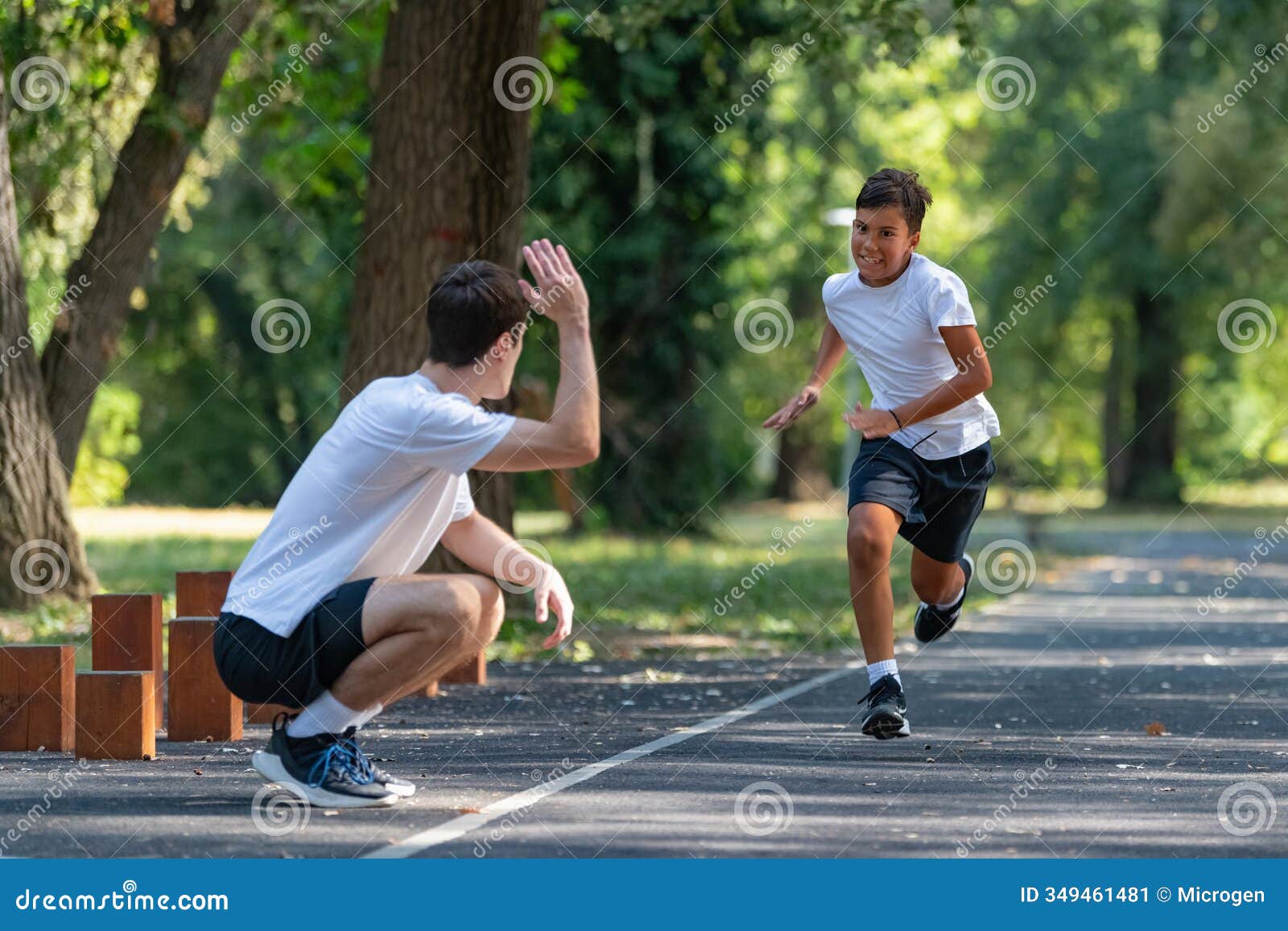 Trainer Works with a Young Boy in the Park, Practicing Speed Running ...