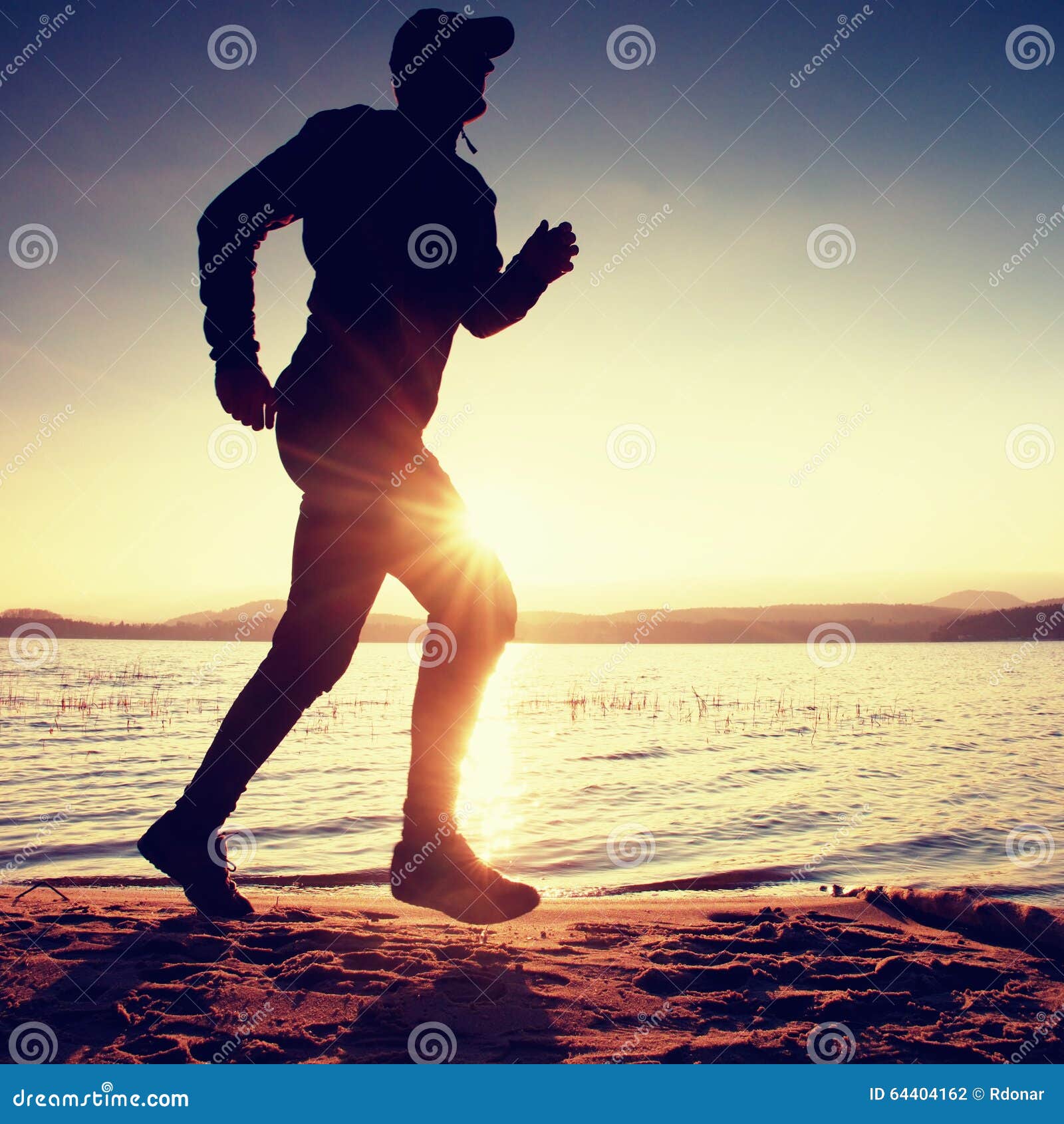 Training at Sunset. a Silhouette of Jogger at Path Along Lake Coastline ...