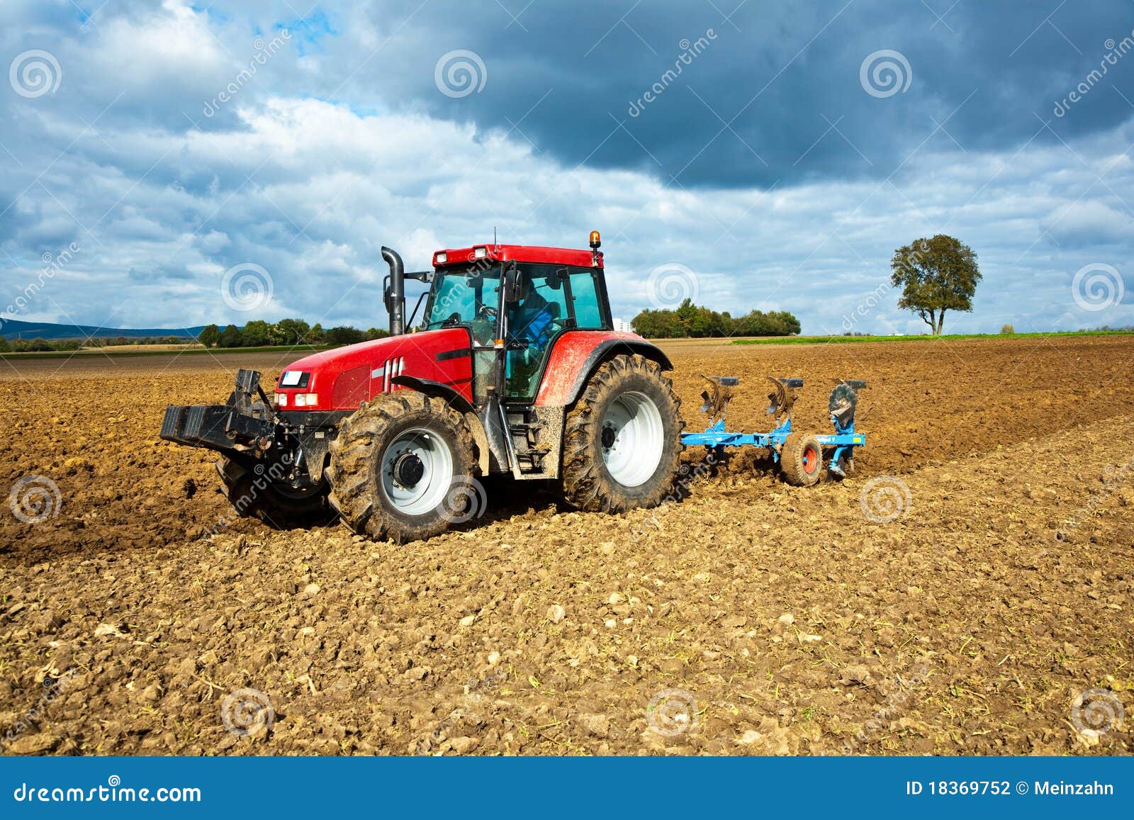 Traktor mit Pflug auf Feld stockfoto. Bild von wiese - 18369752