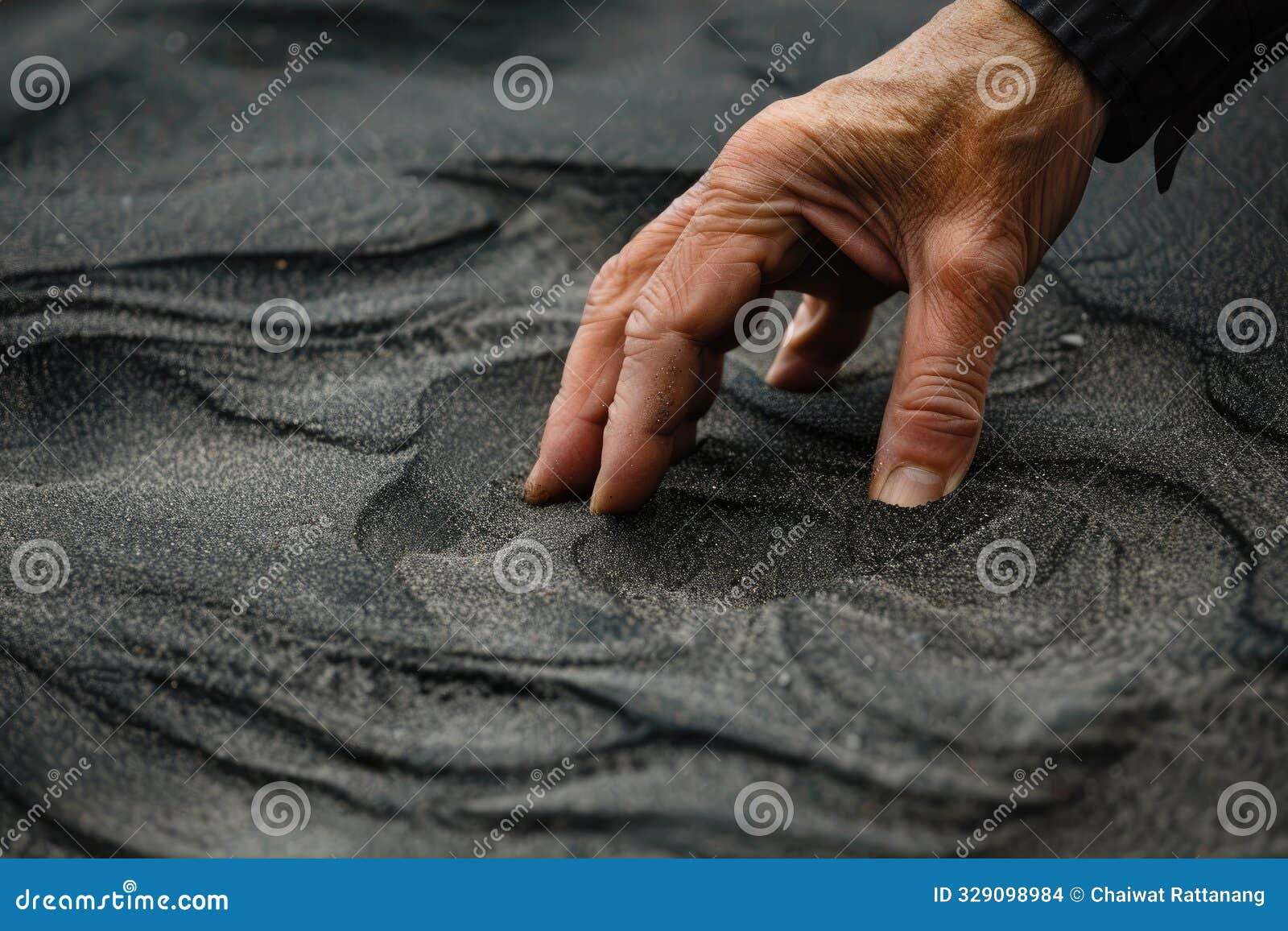 Tranquil Beauty of Hand Drawing Patterns in Sand with Black Rock ...