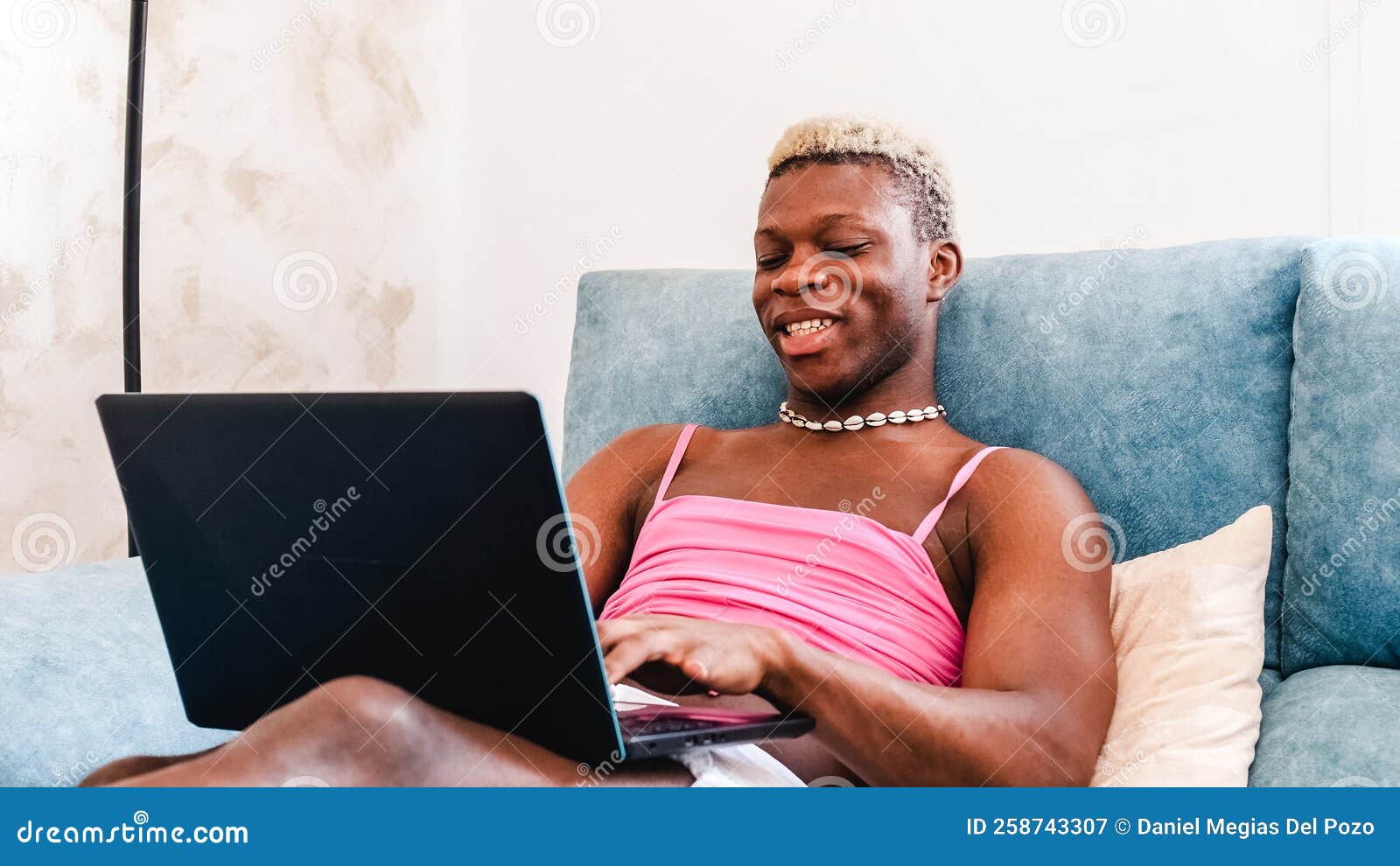 Transgender Man Using a Laptop Computer while Relaxing Sitting on a ...
