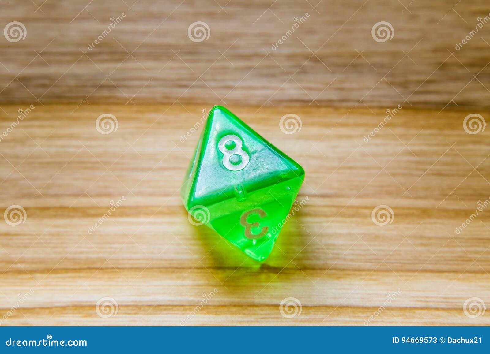 A Translucent Green Eight Sided Playing Dice on a Wooden Background ...