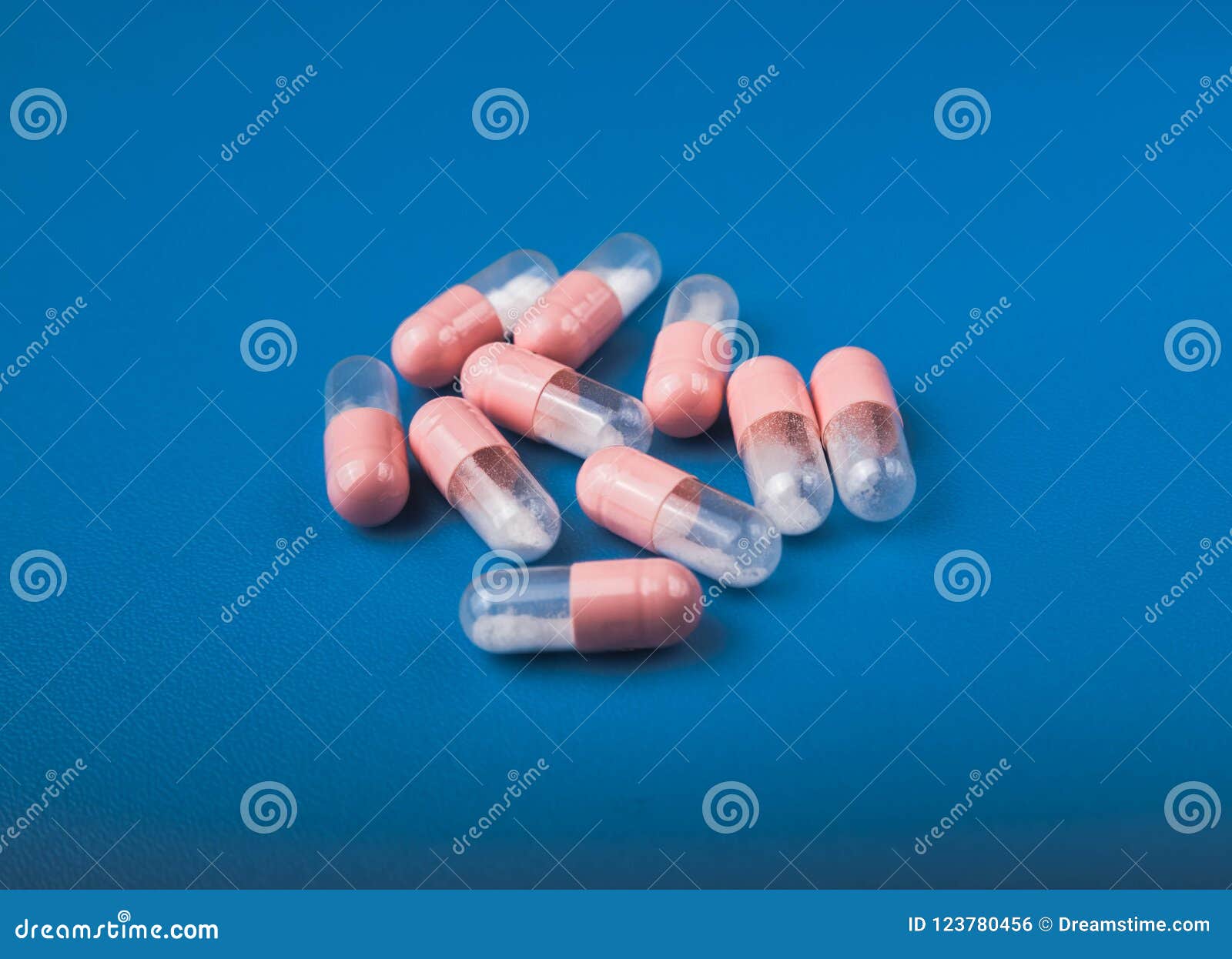 Transparent Capsules with White Powder Inside on a Blue Background ...