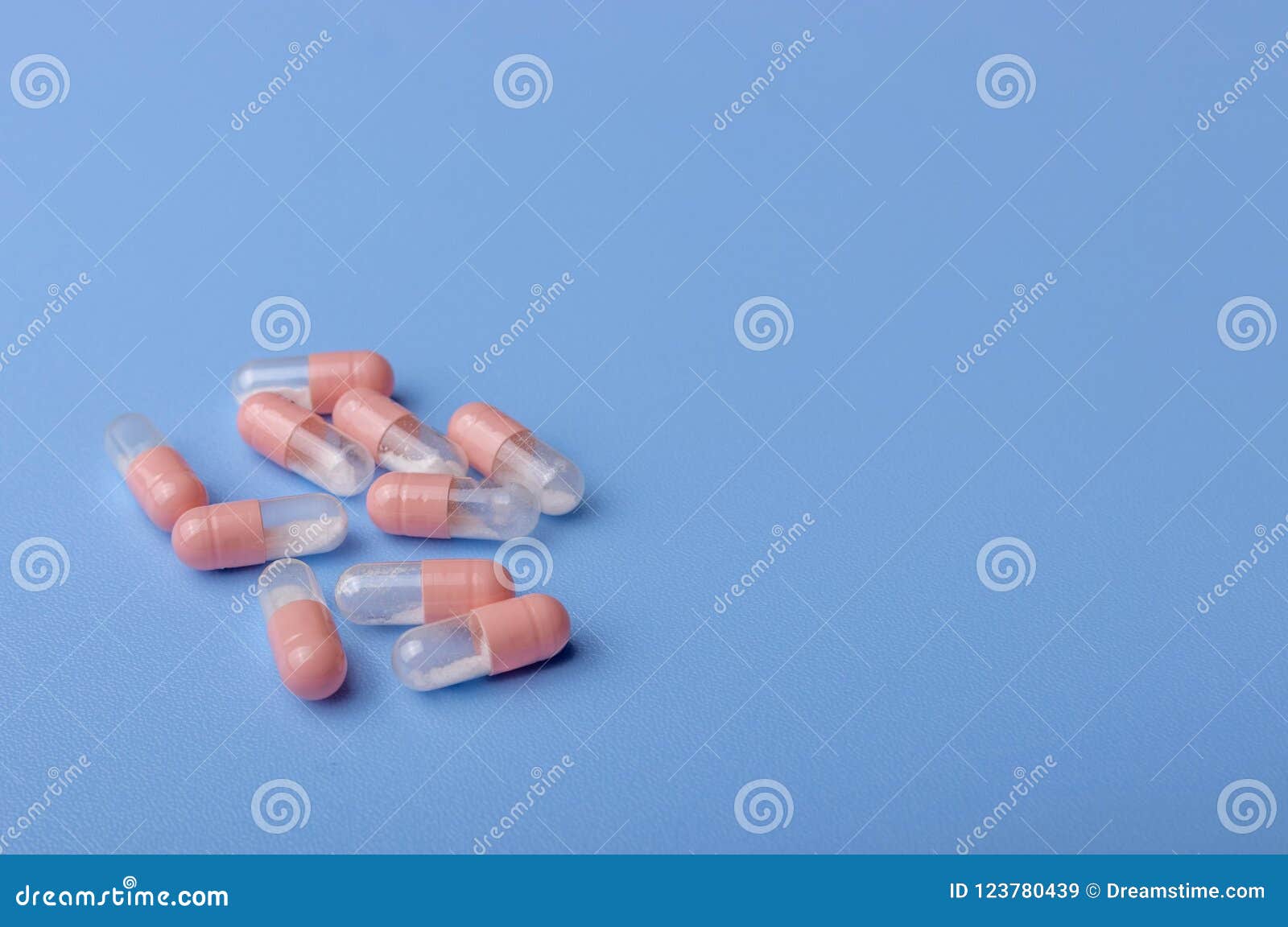 Transparent Capsules with White Powder Inside on a Blue Background ...