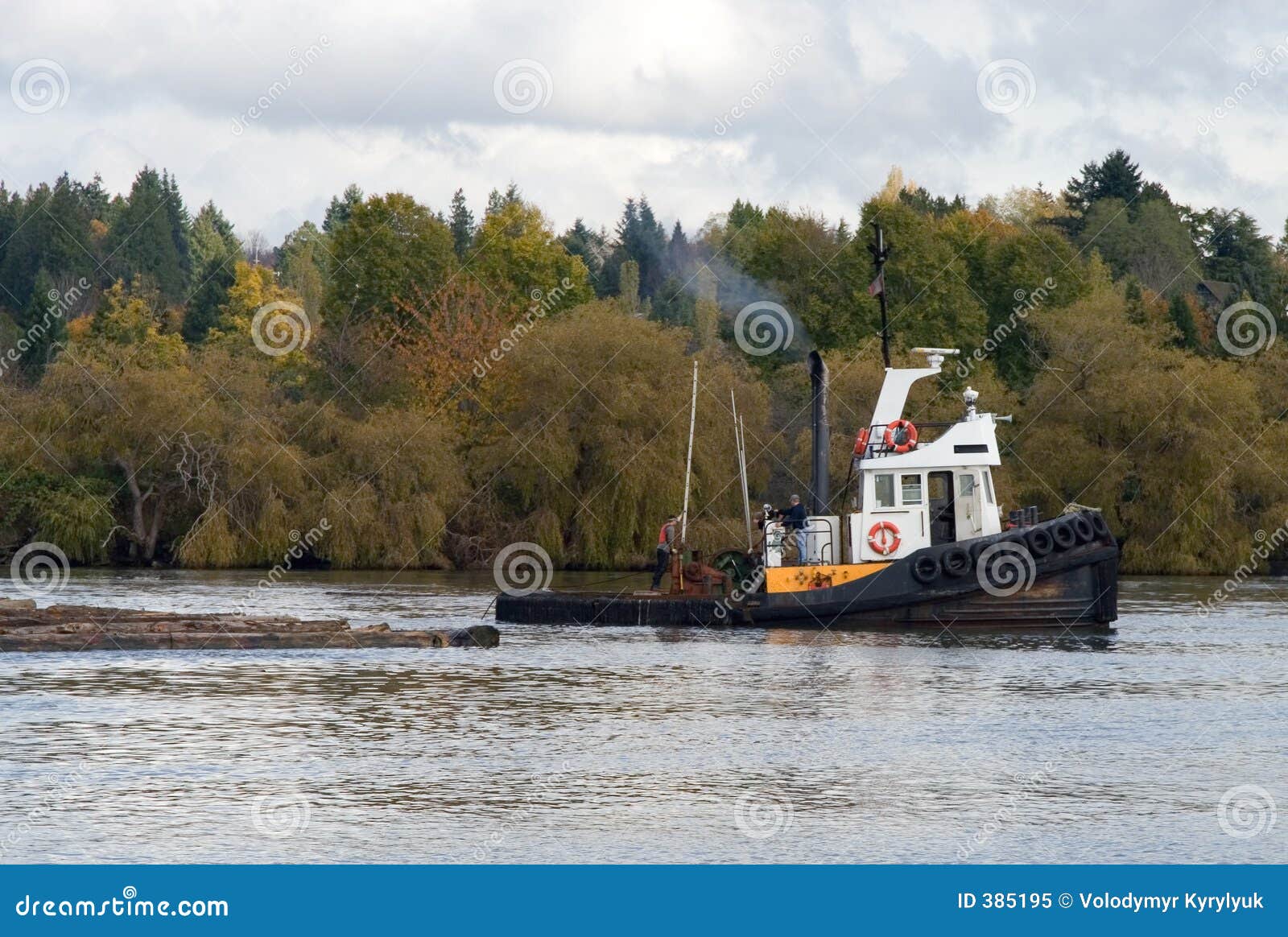 A Working Tugboat Towing A Cargo Ship Full Of Logs On A River Royalty ...