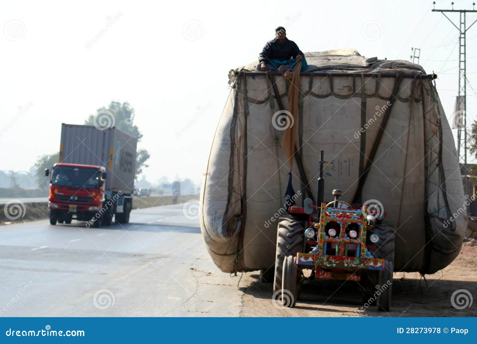 An Overloaded Trailer Pulled By A Small Donkey And A Horse Through The ...
