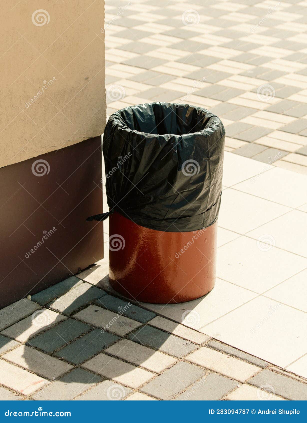 Trash Can in Front of a Wall in a City Park Stock Image - Image of ...