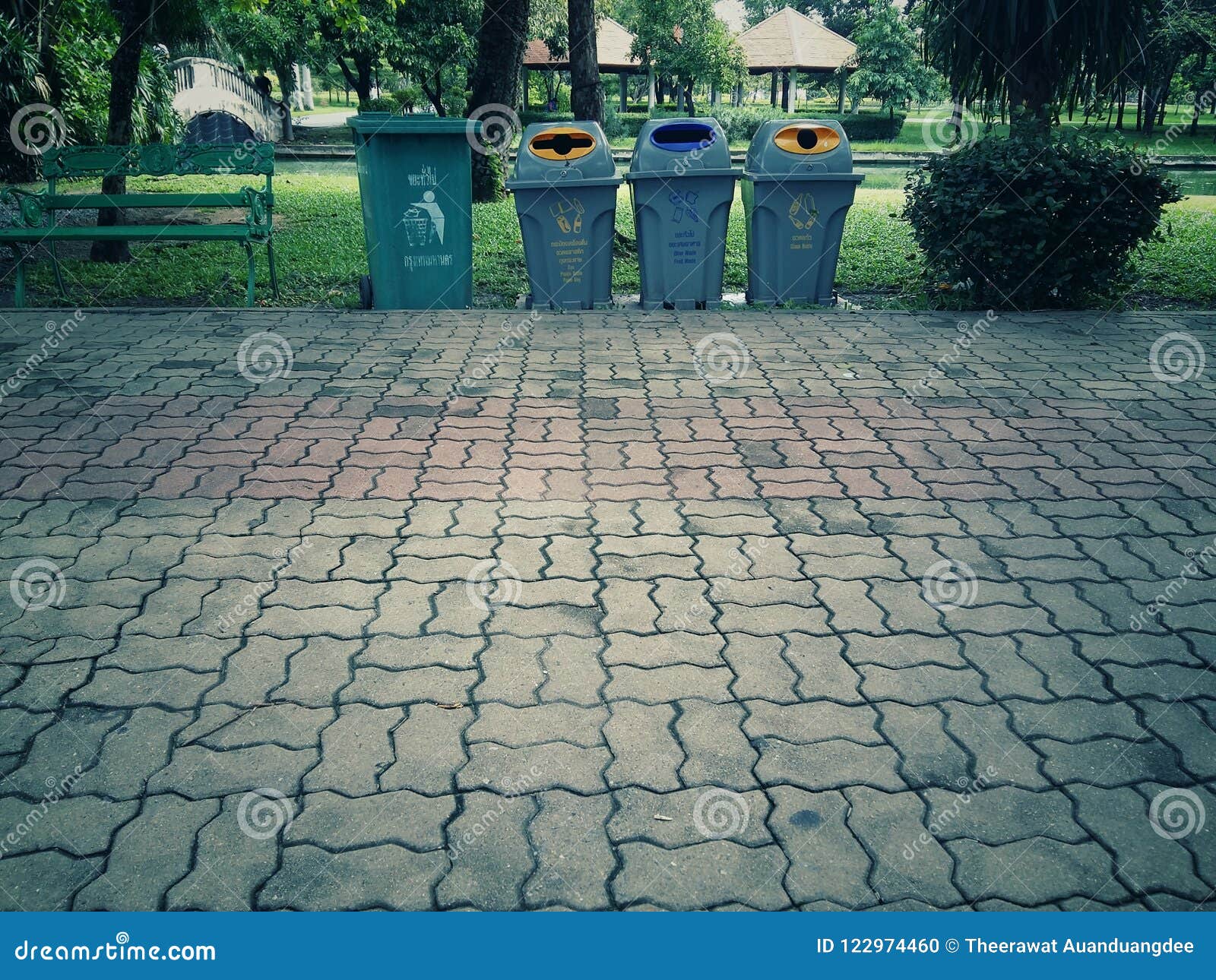 Trash Can In Park Alongside Stone Brick Wall On Gravel Walkway Stock ...