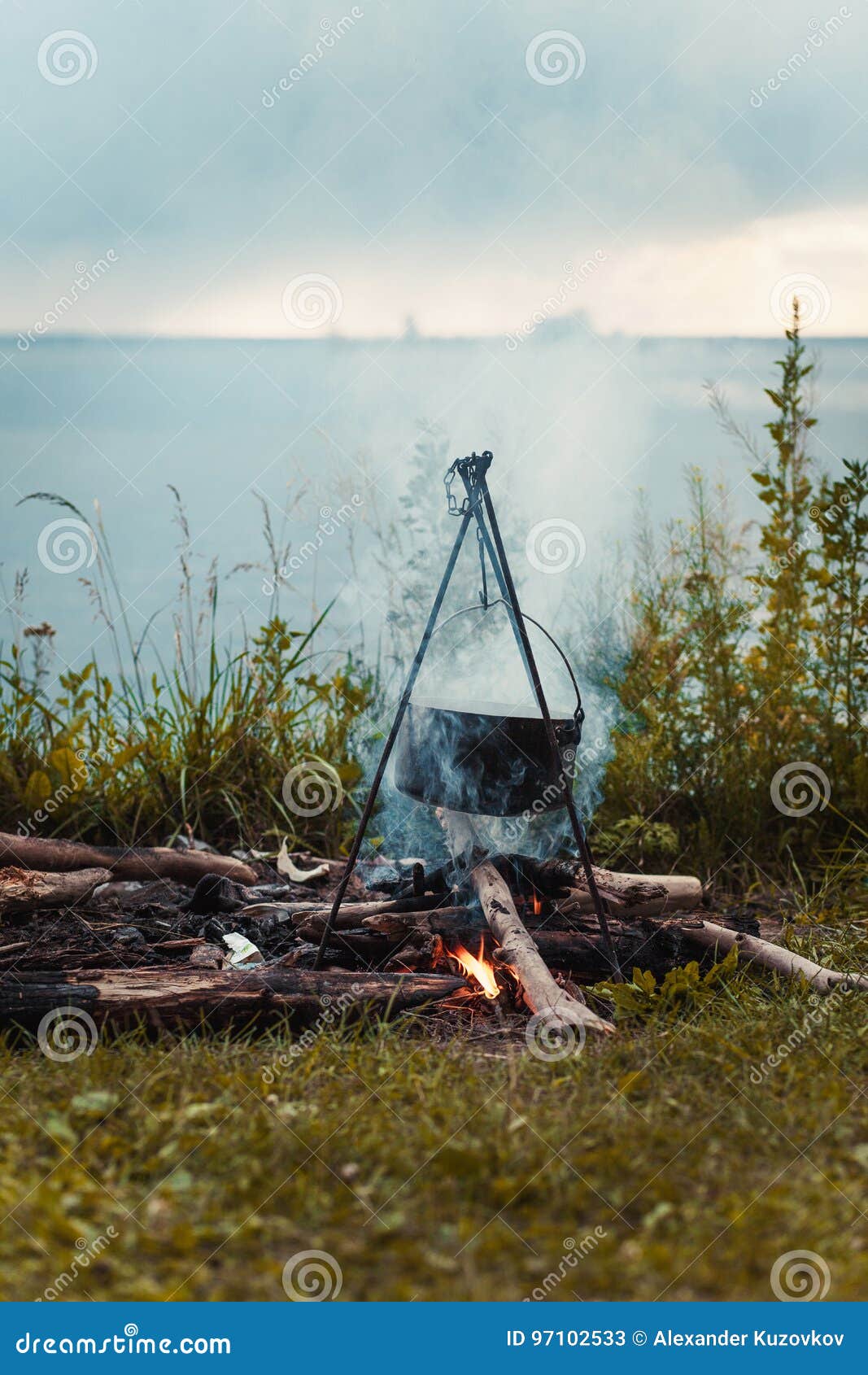 Travel a Kettle Over a Fire Burning on the River and Sunset Backgroun ...