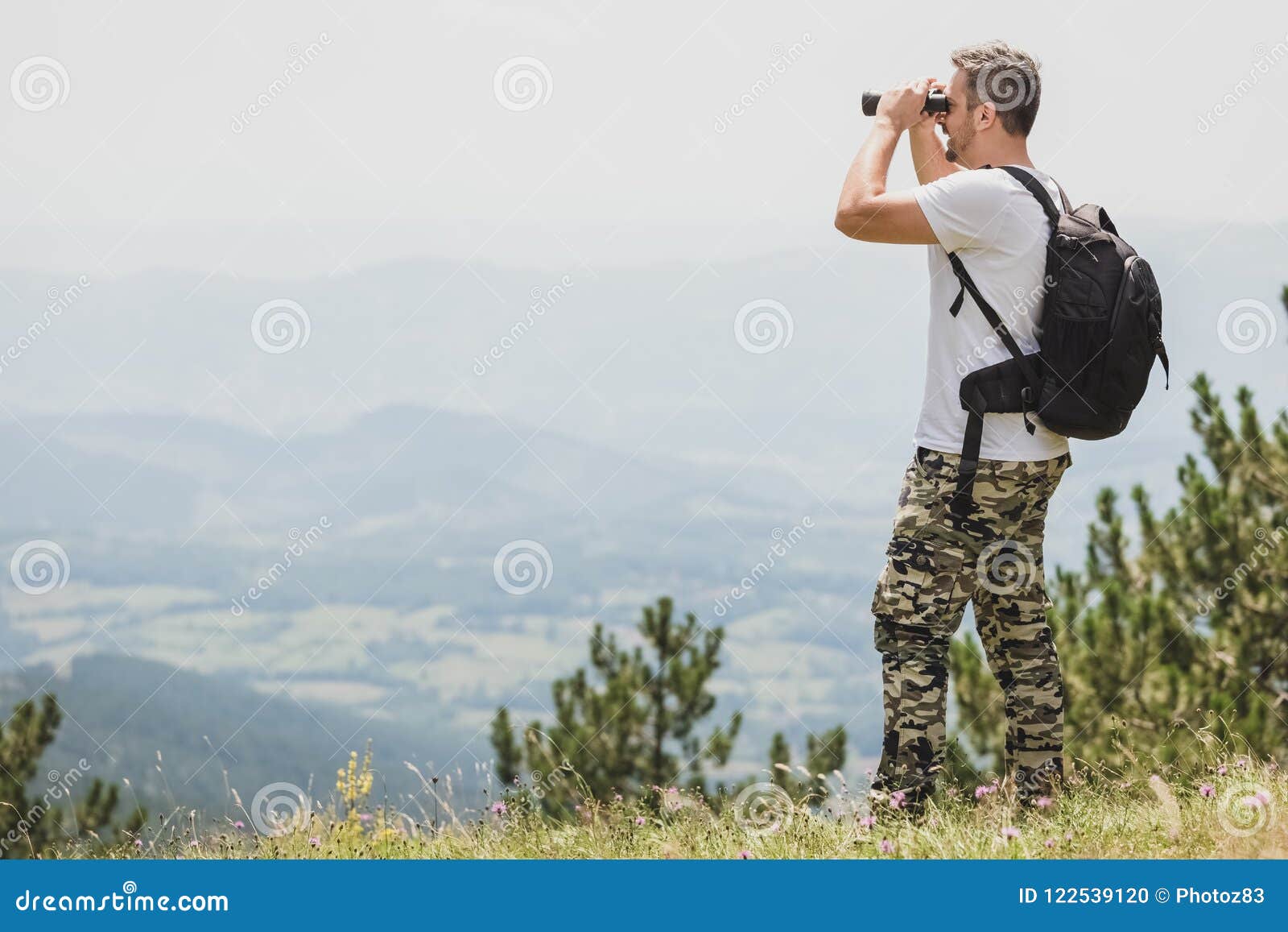 Traveler with Backpack Standing on the Top of the Mountain and Using ...