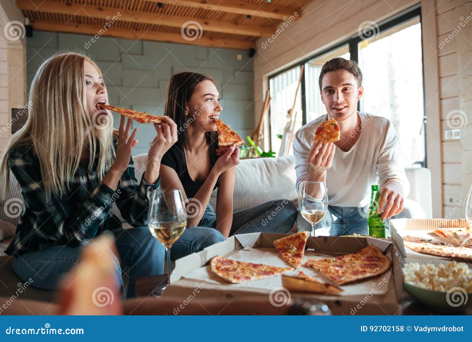 Tre Amici Che Mangiano Pizza in Casa Fotografia Stock - Immagine di ...