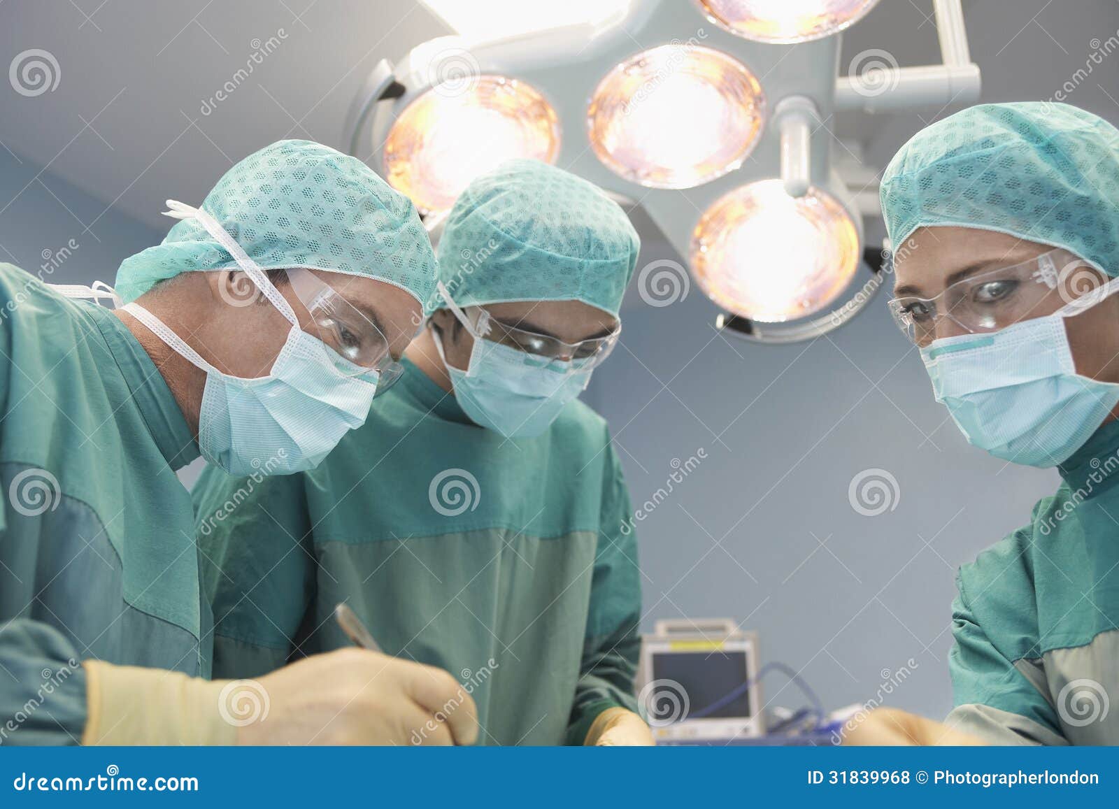 Tre Kirurger På Arbete I Operationssal Arkivfoto - Bild av glasögon ...