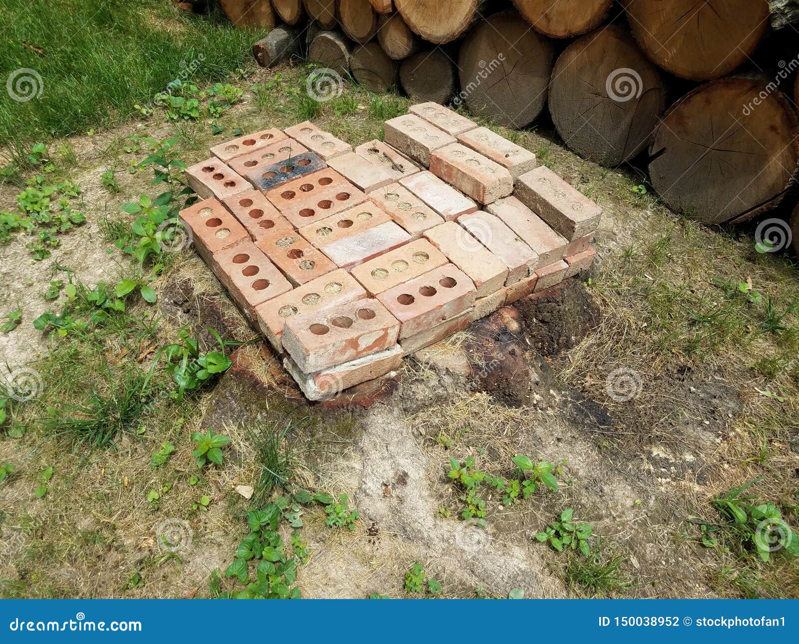 Tree Stump with Red Bricks and Stacked Firewood Stock Photo - Image of ...