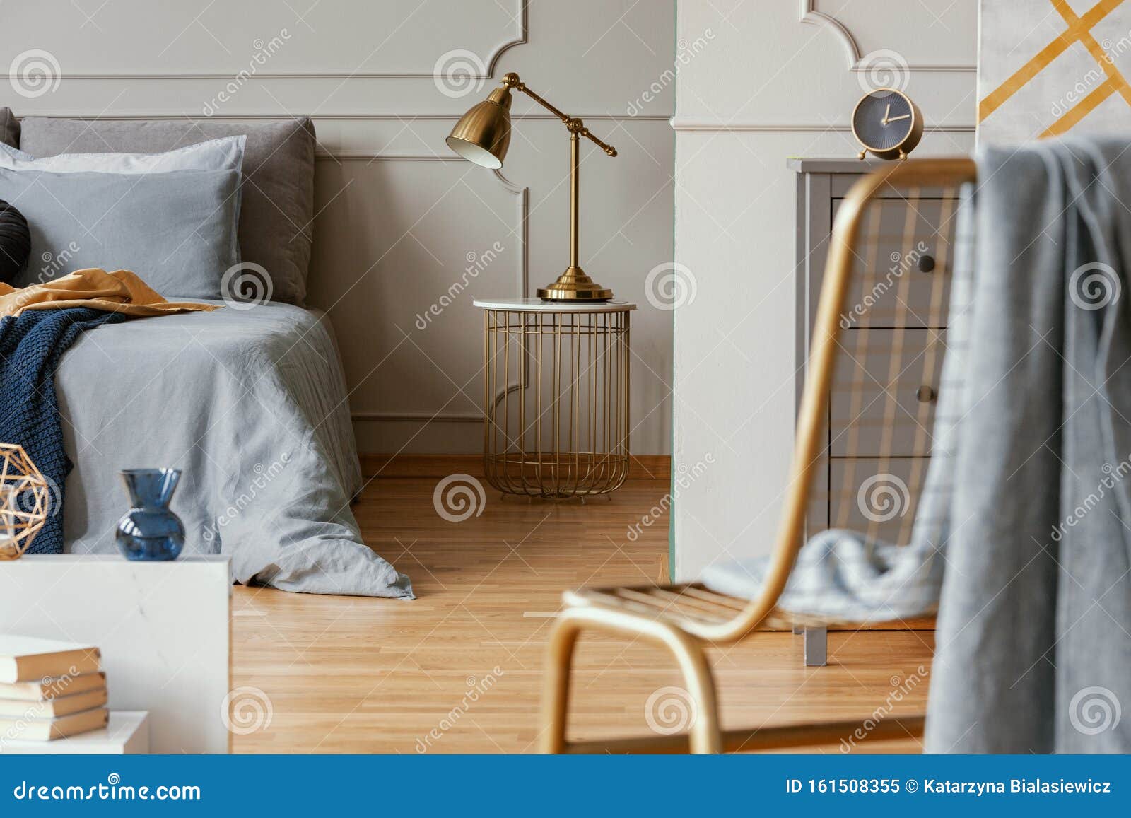 Trendy Bedroom Interior with Grey Commode and Golden Chair Stock Image ...